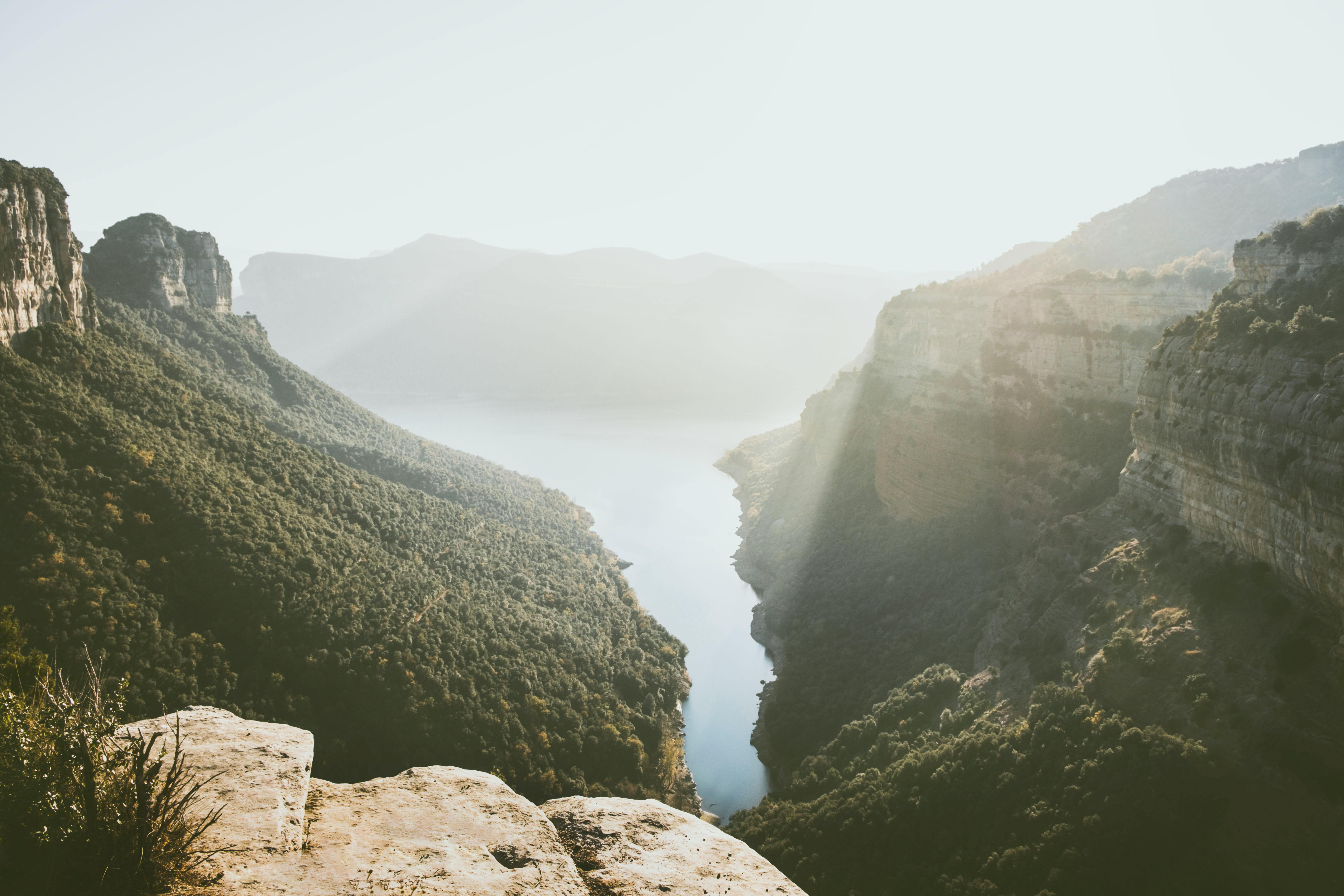 Rocky ravine between tranquil river in nature · Free Stock Photo