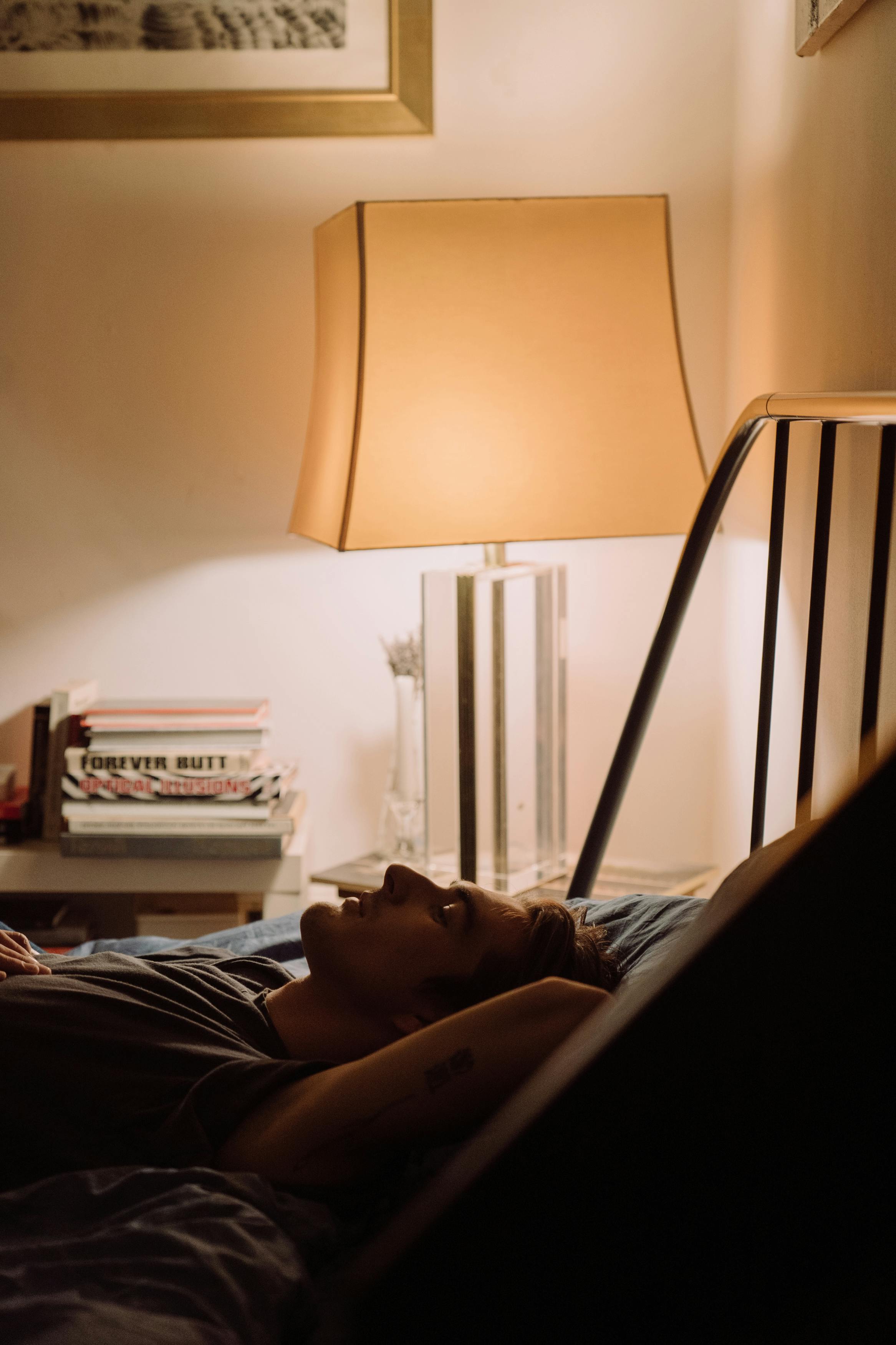 A Man Reading Book while Sitting on a Bed · Free Stock Photo