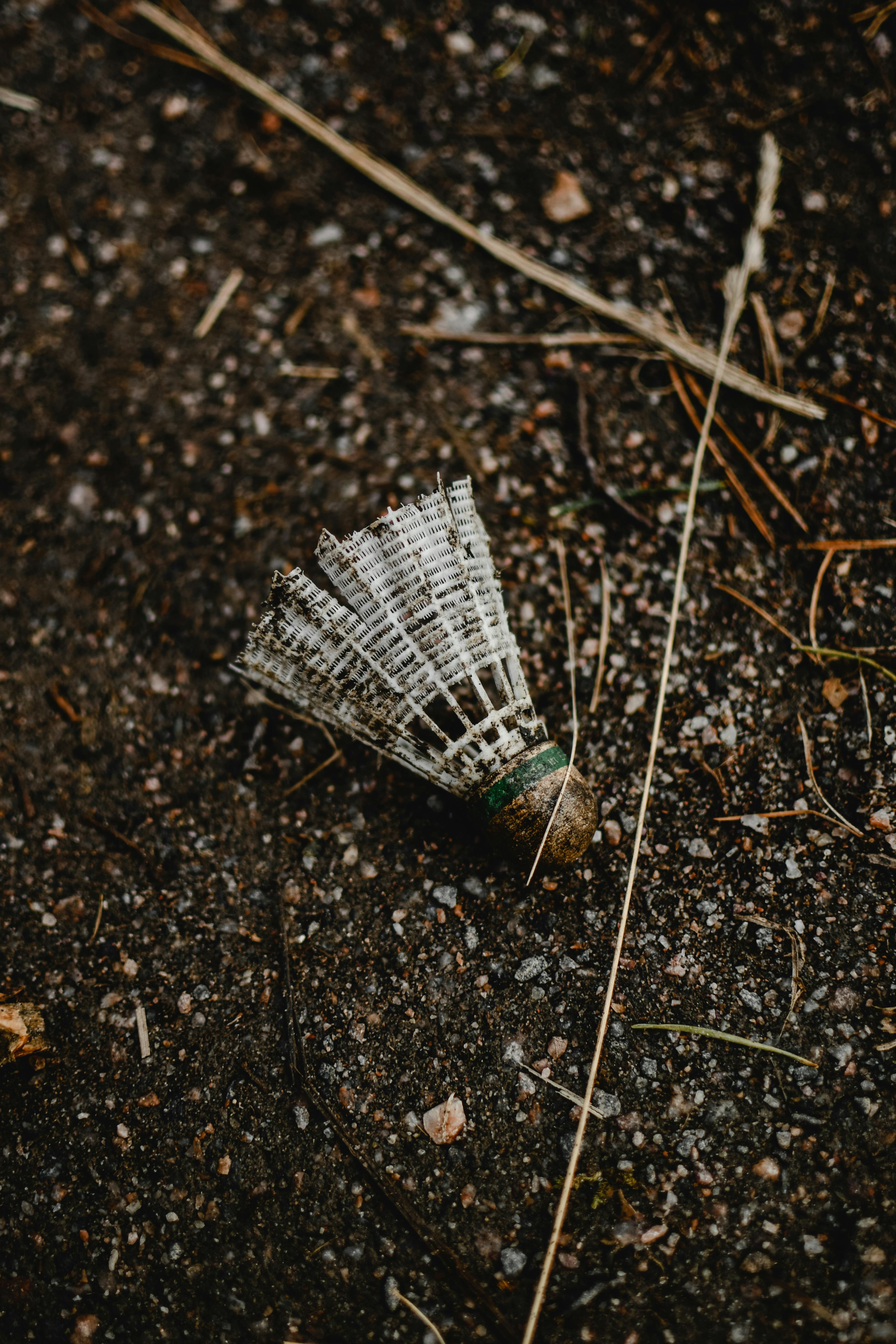 A Dirty Shuttlecock on the Ground · Free Stock Photo