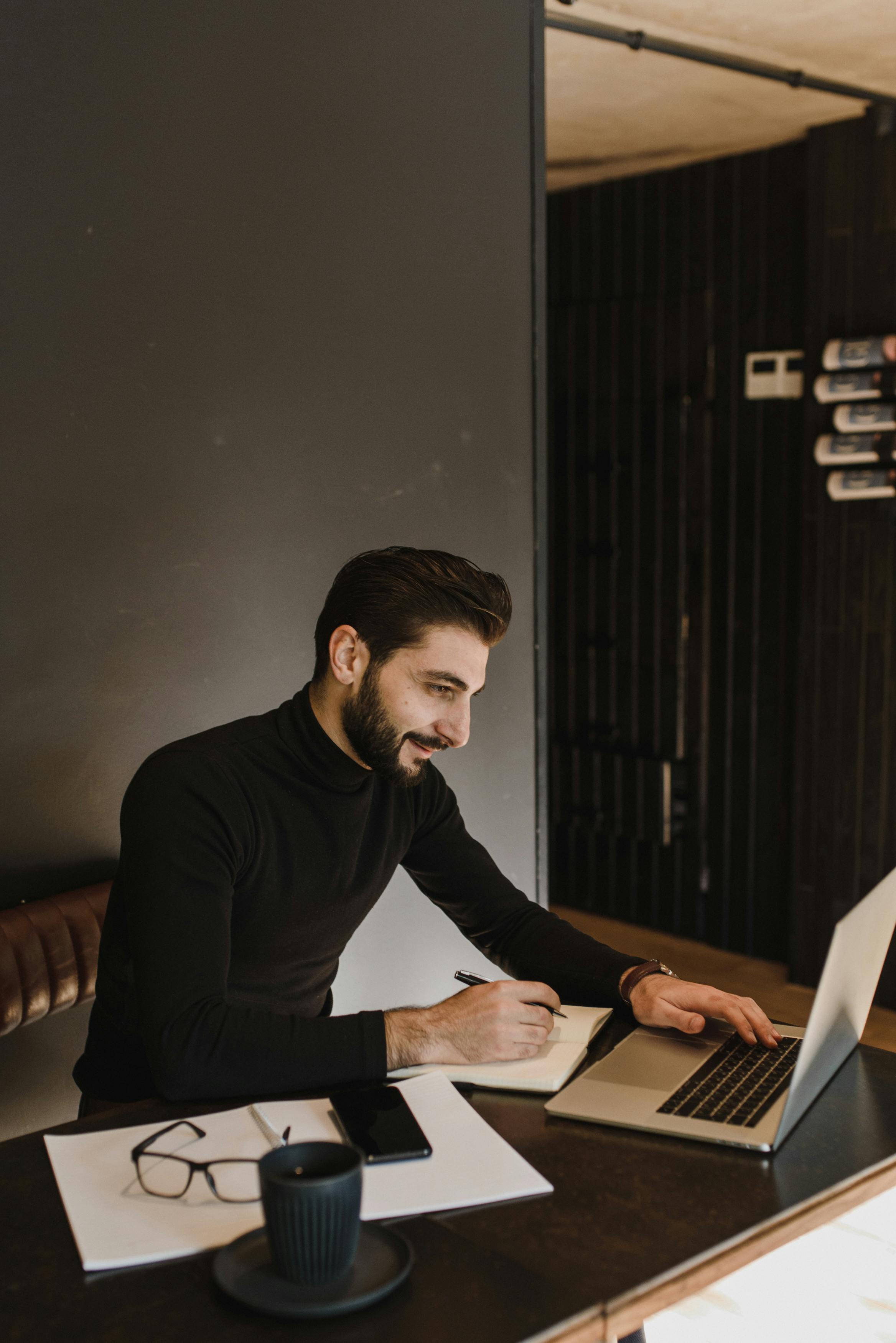 A Man in Black Sweater While using Laptop · Free Stock Photo