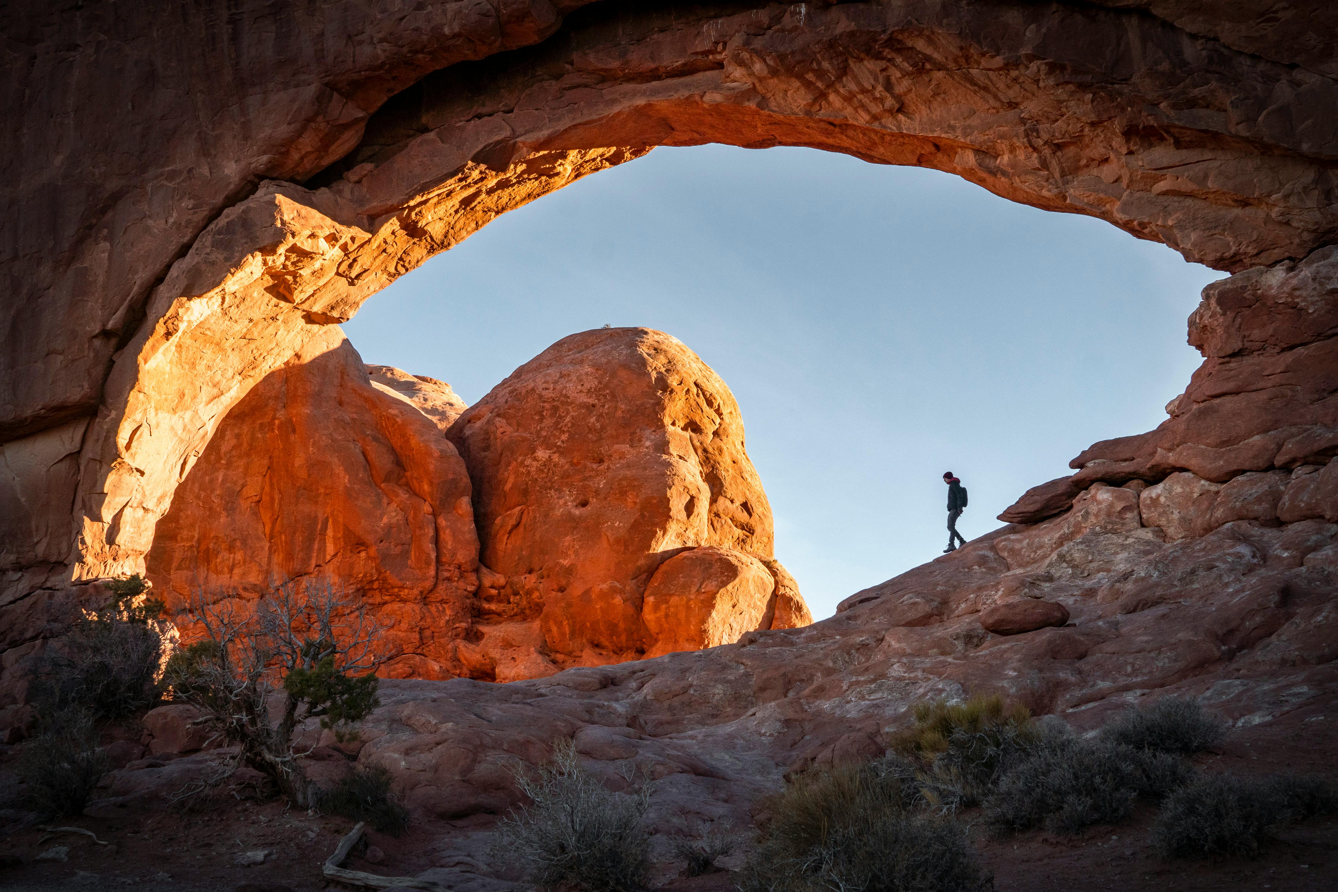 A Person Standing Under a Natural Arch · Free Stock Photo
