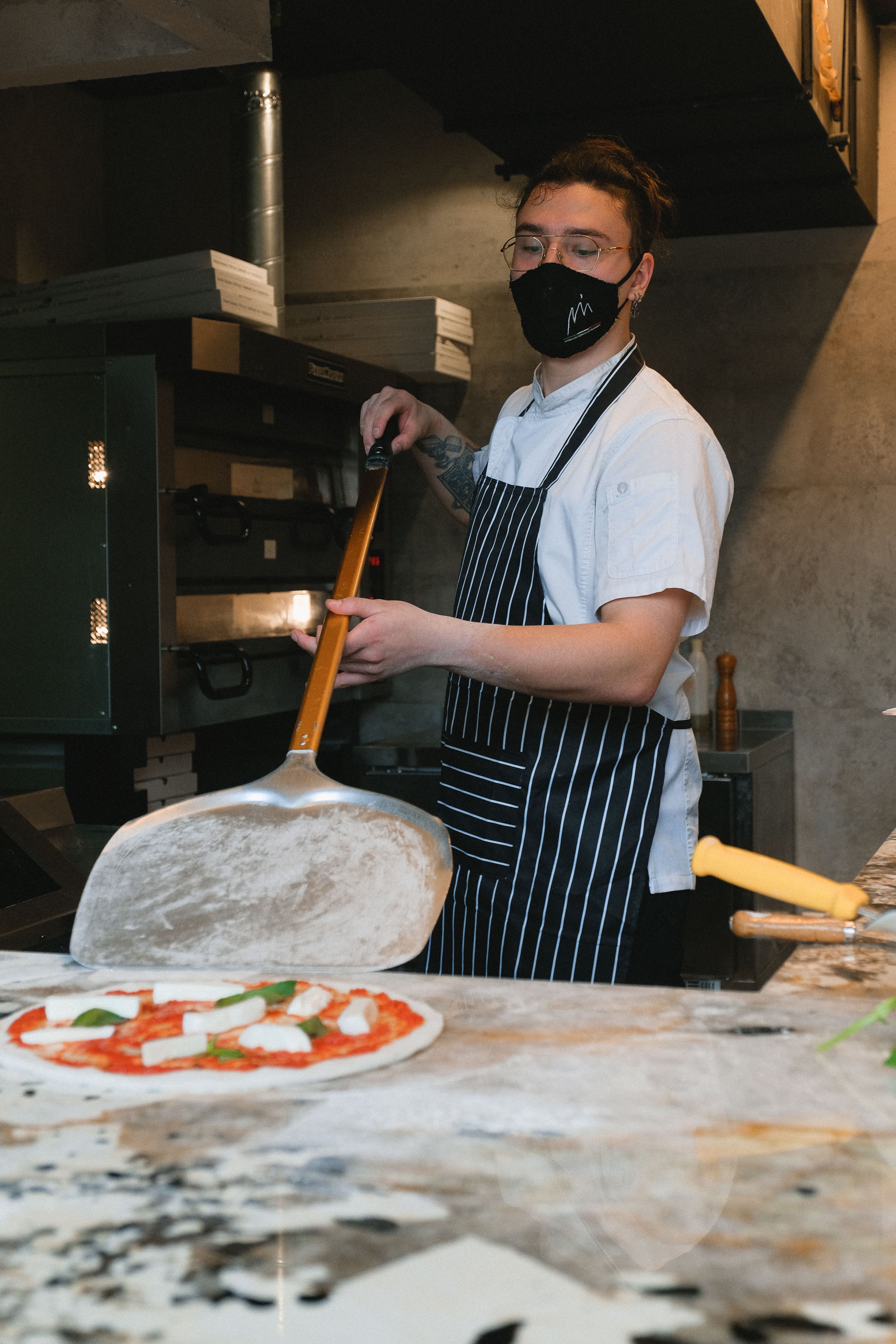 Pizzerman Putting Pizza on a Counter with a Pizza Shovel · Free Stock Photo