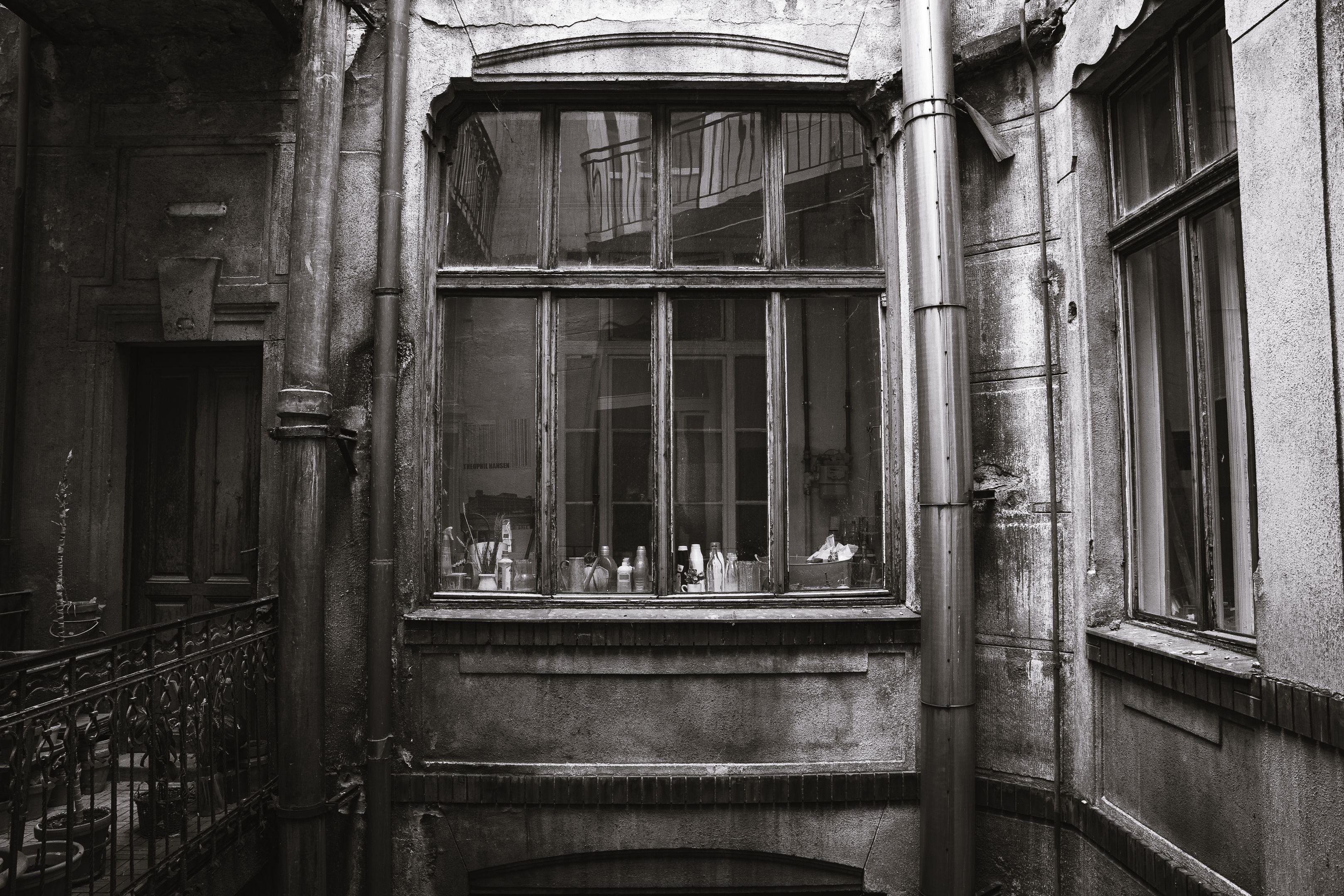 Grayscale Photo of a Stained Glass Window with Grills · Free Stock Photo