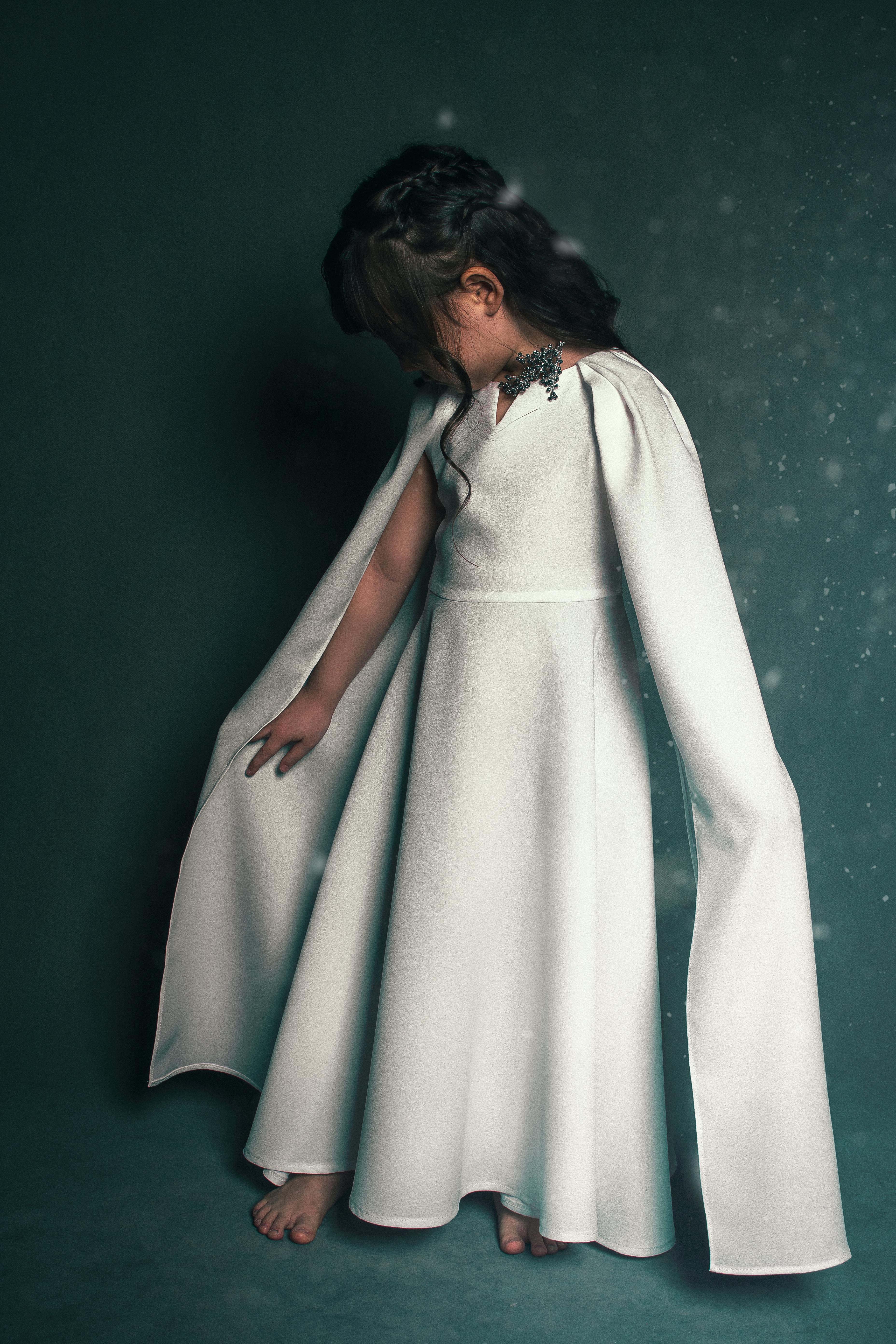 Beautiful little kid in white dress with cape · Free Stock Photo