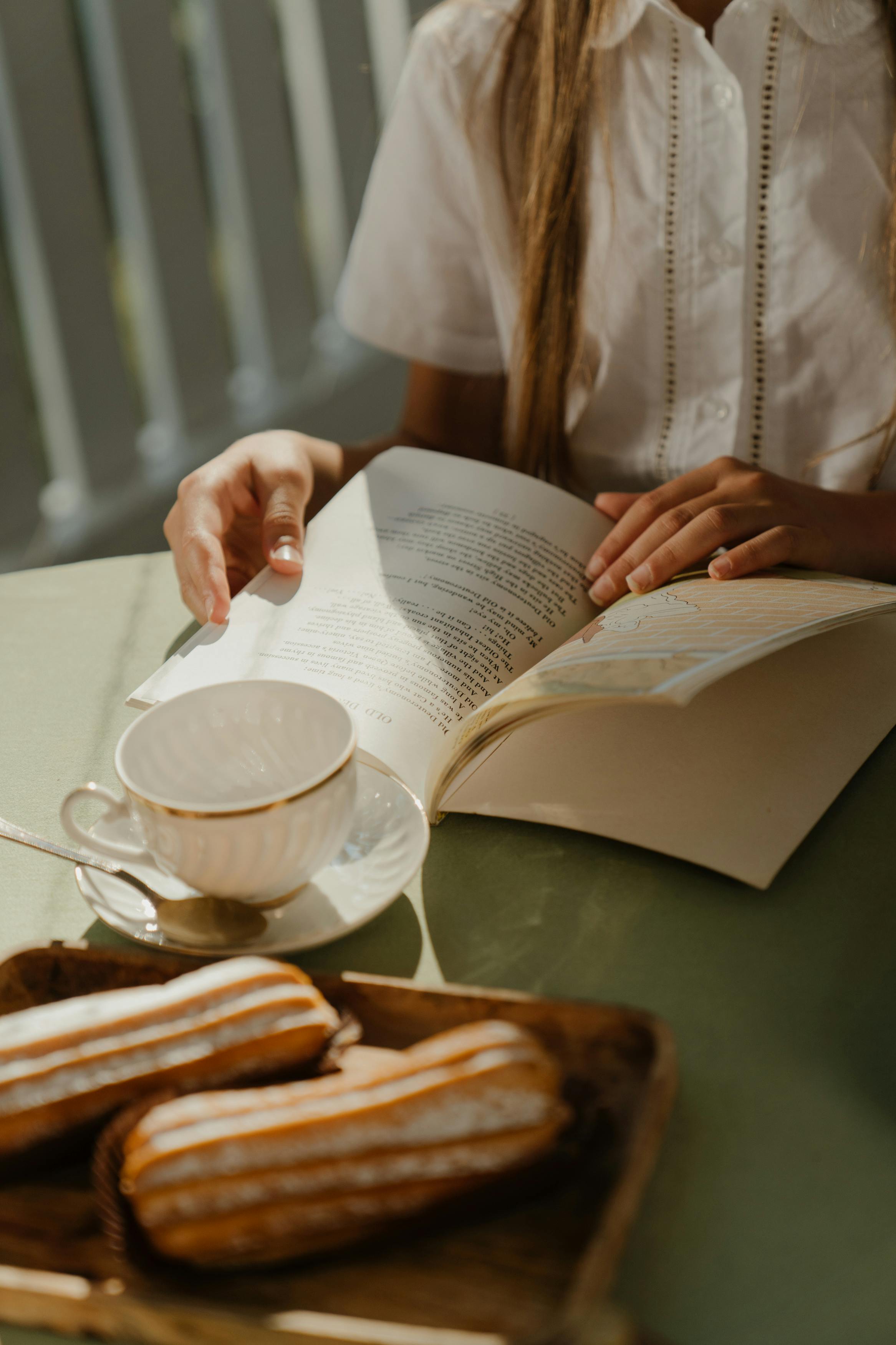 Person Reading a Book on a Table · Free Stock Photo