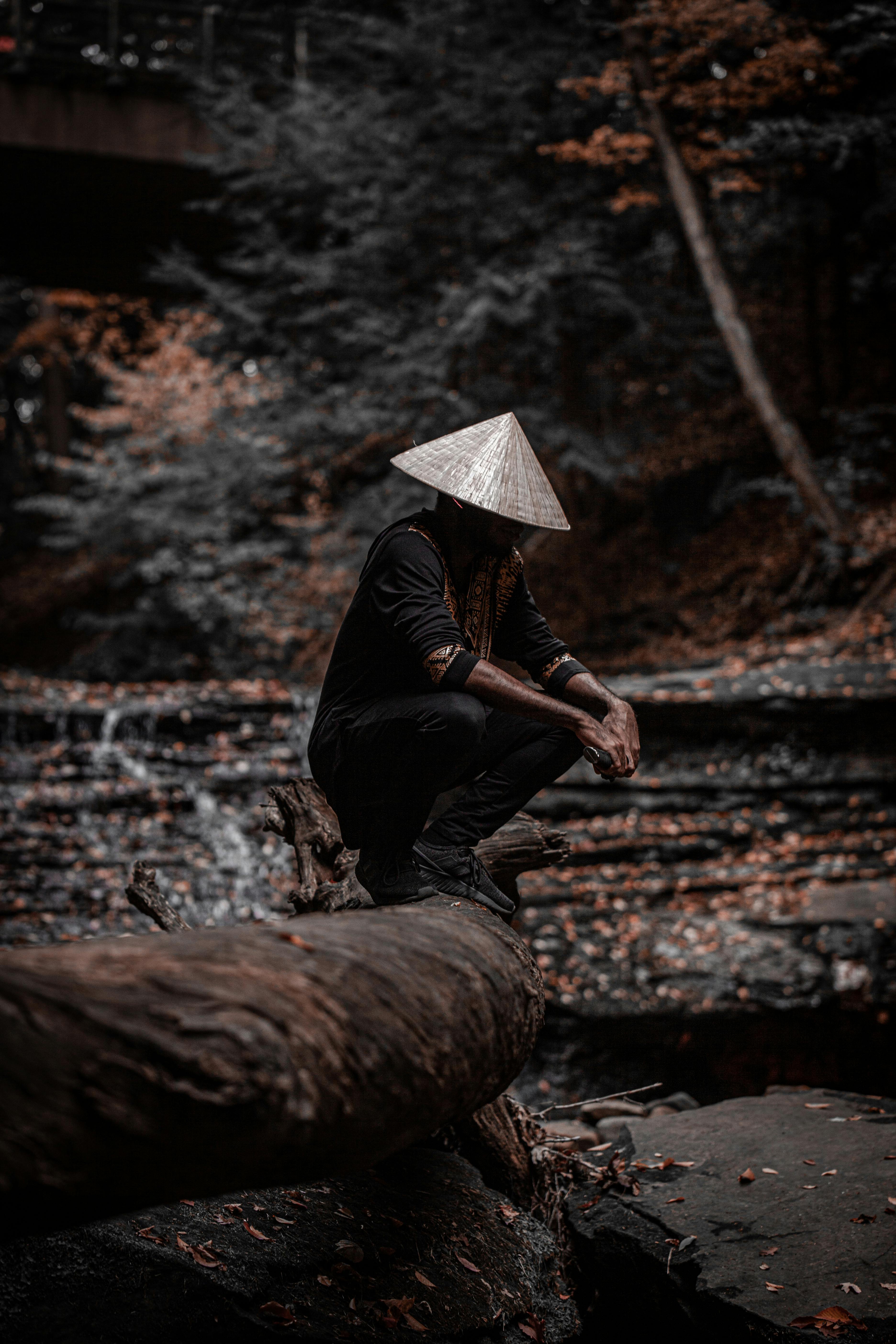 Person Crouching on Tree Trunk · Free Stock Photo
