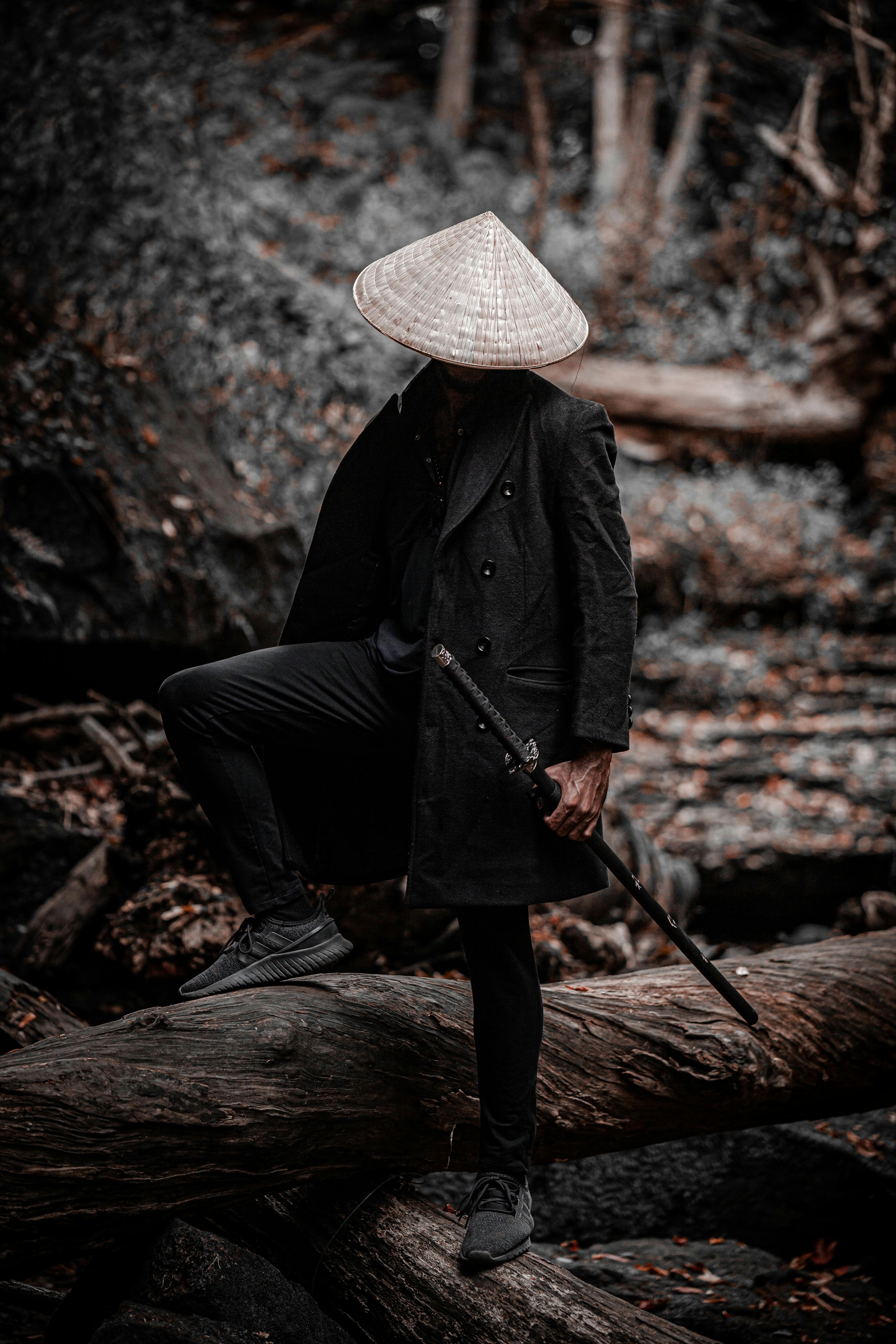 Person Stepping on Tree Trunk While Holding a Sword · Free Stock Photo
