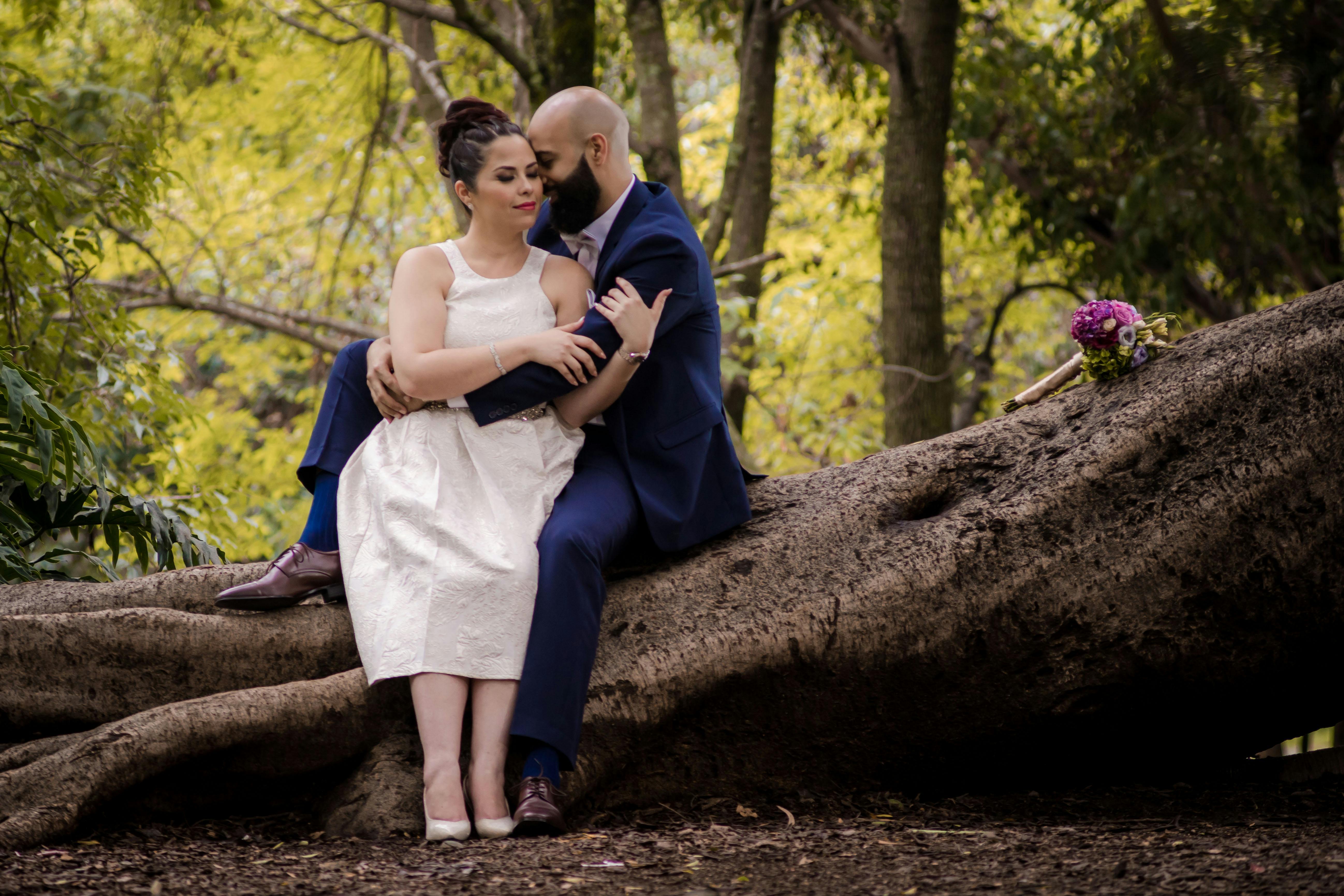 Married Couple Sitting on Tree Root · Free Stock Photo