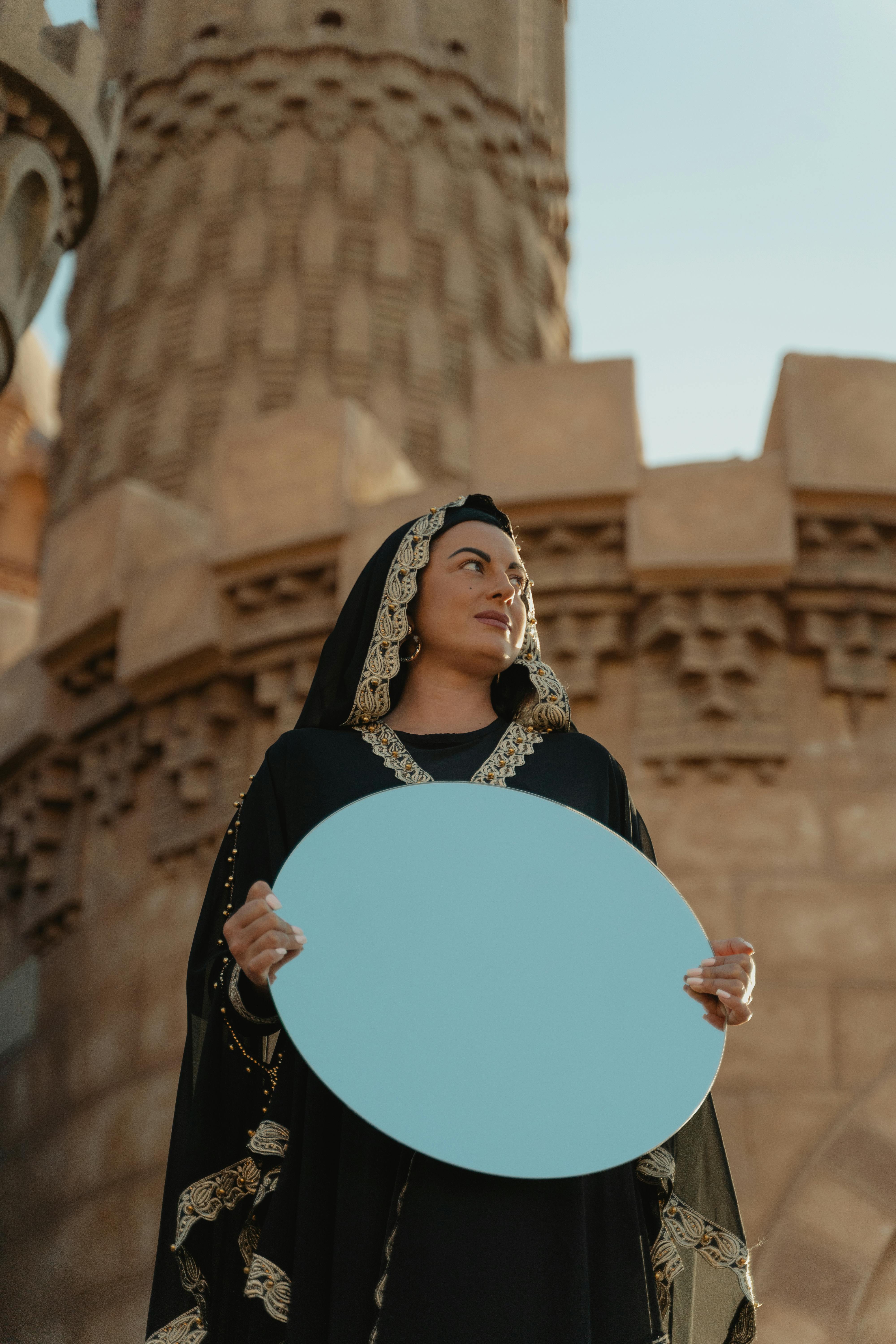 A Woman Wearing a Black Robe Holding a Mirror · Free Stock Photo
