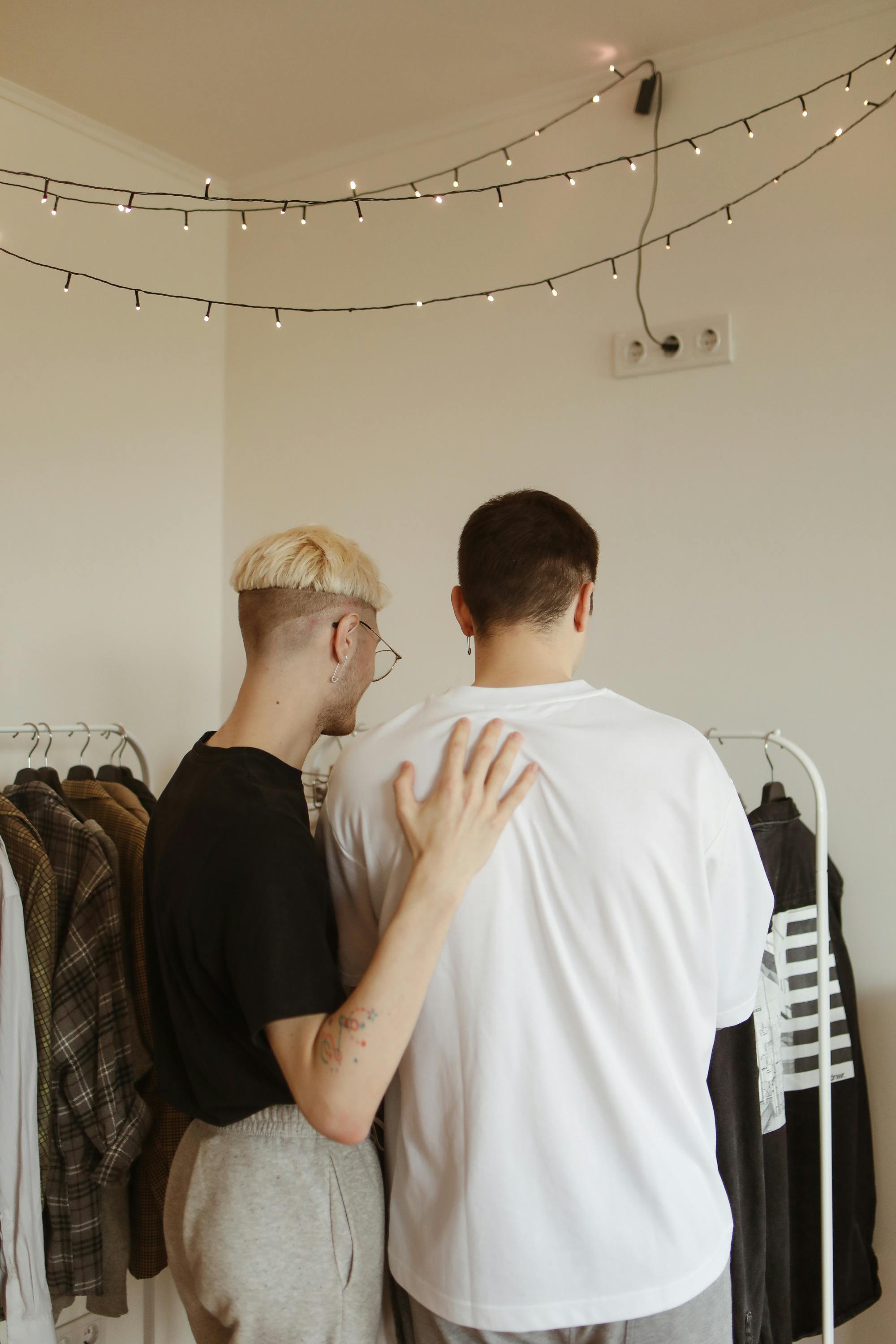 A Couple Choosing Clothes from a Clothing Rack · Free Stock Photo