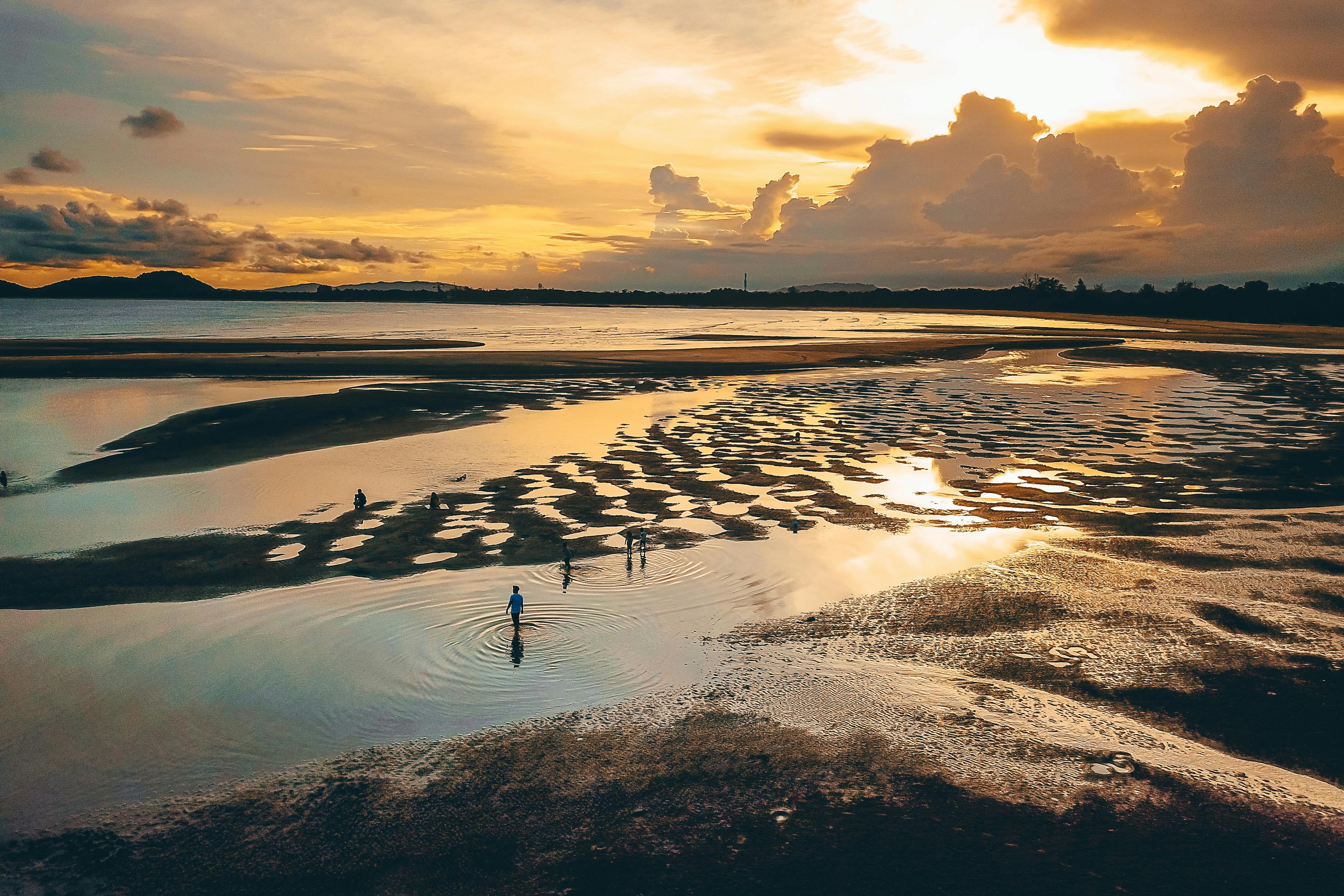 Anonymous surfers recreating on rocky cliff in front of powerful ocean ...