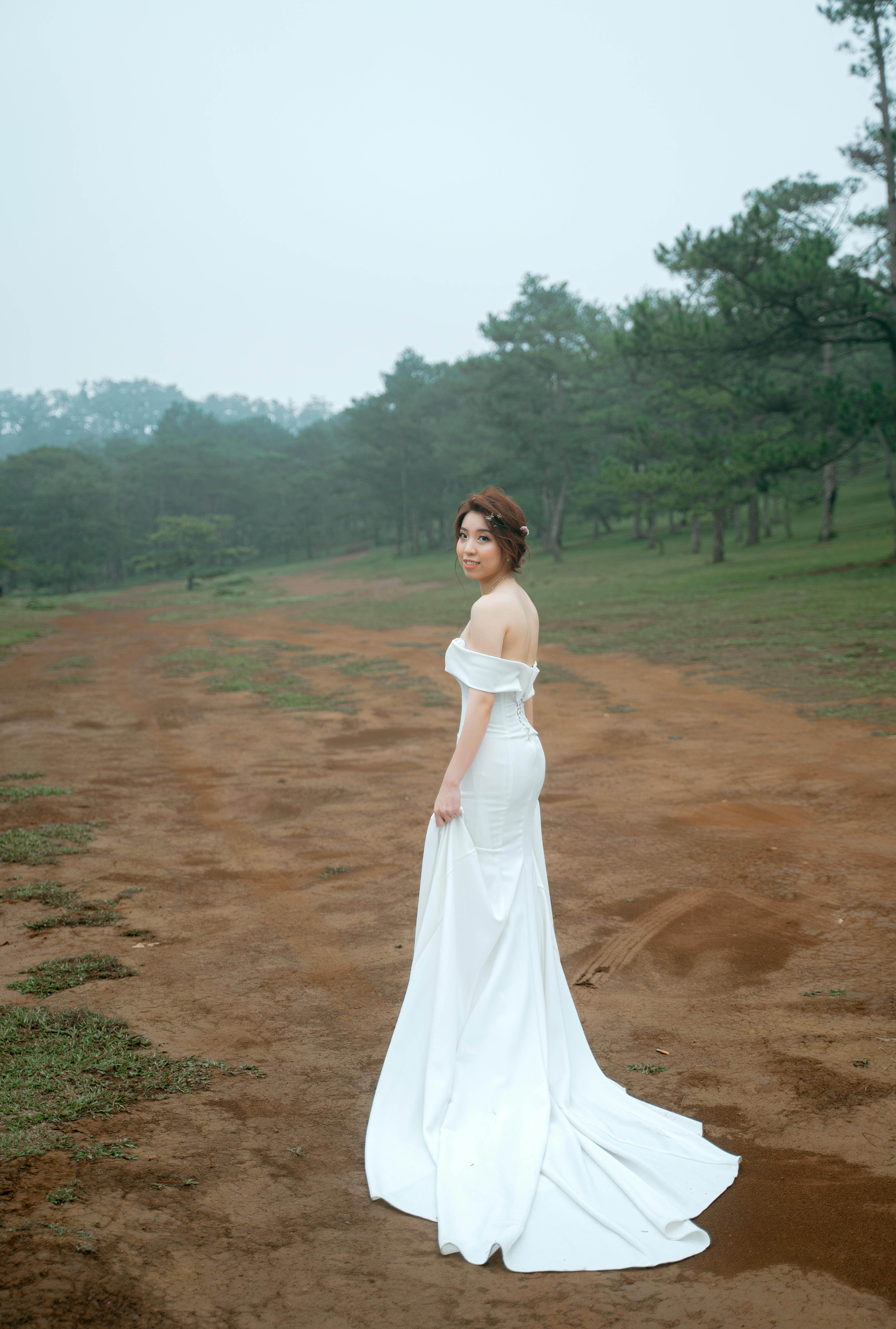 Elegant young Asian bride relaxing in green park · Free Stock Photo