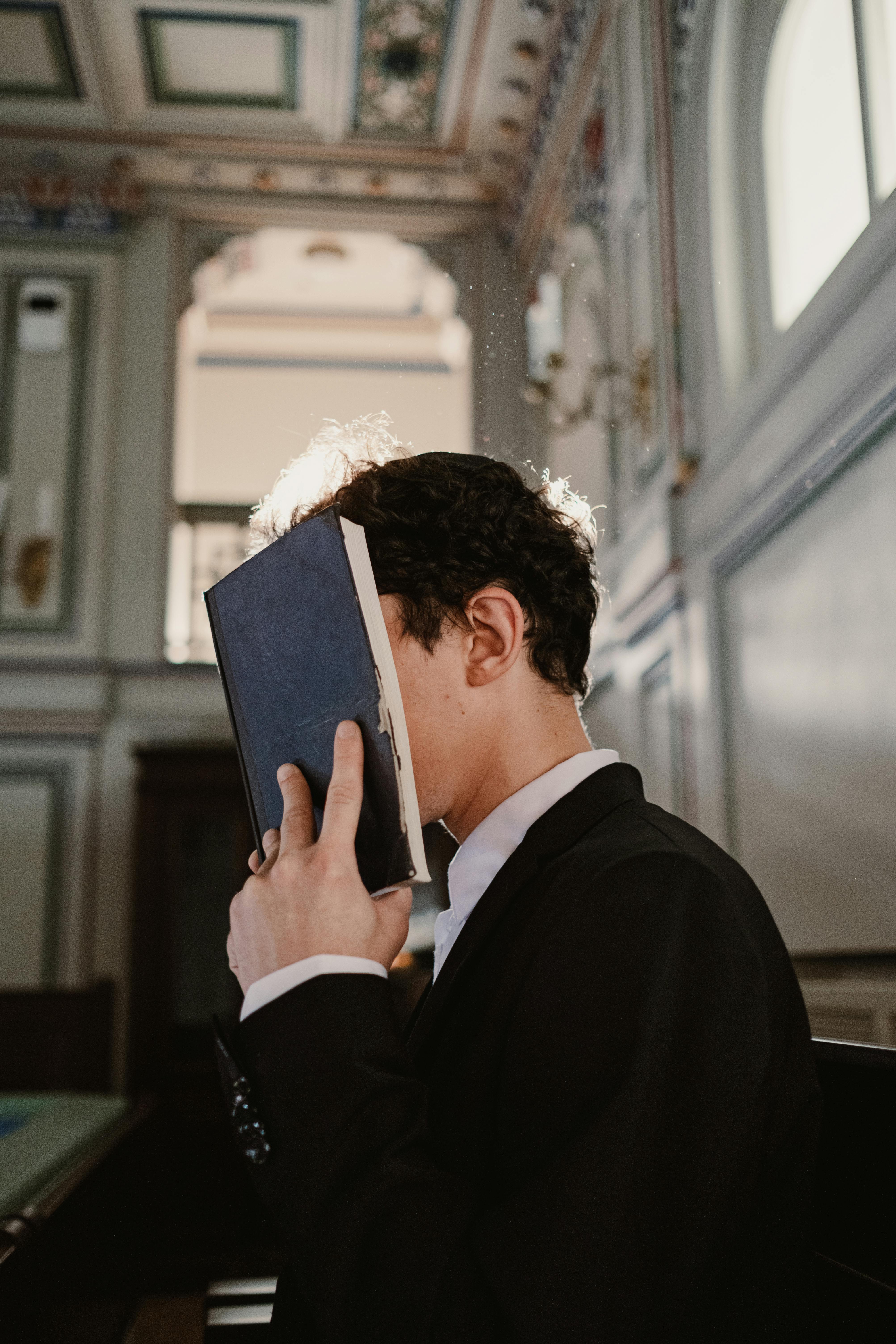 Man in Black Suit Holding Blue Book · Free Stock Photo