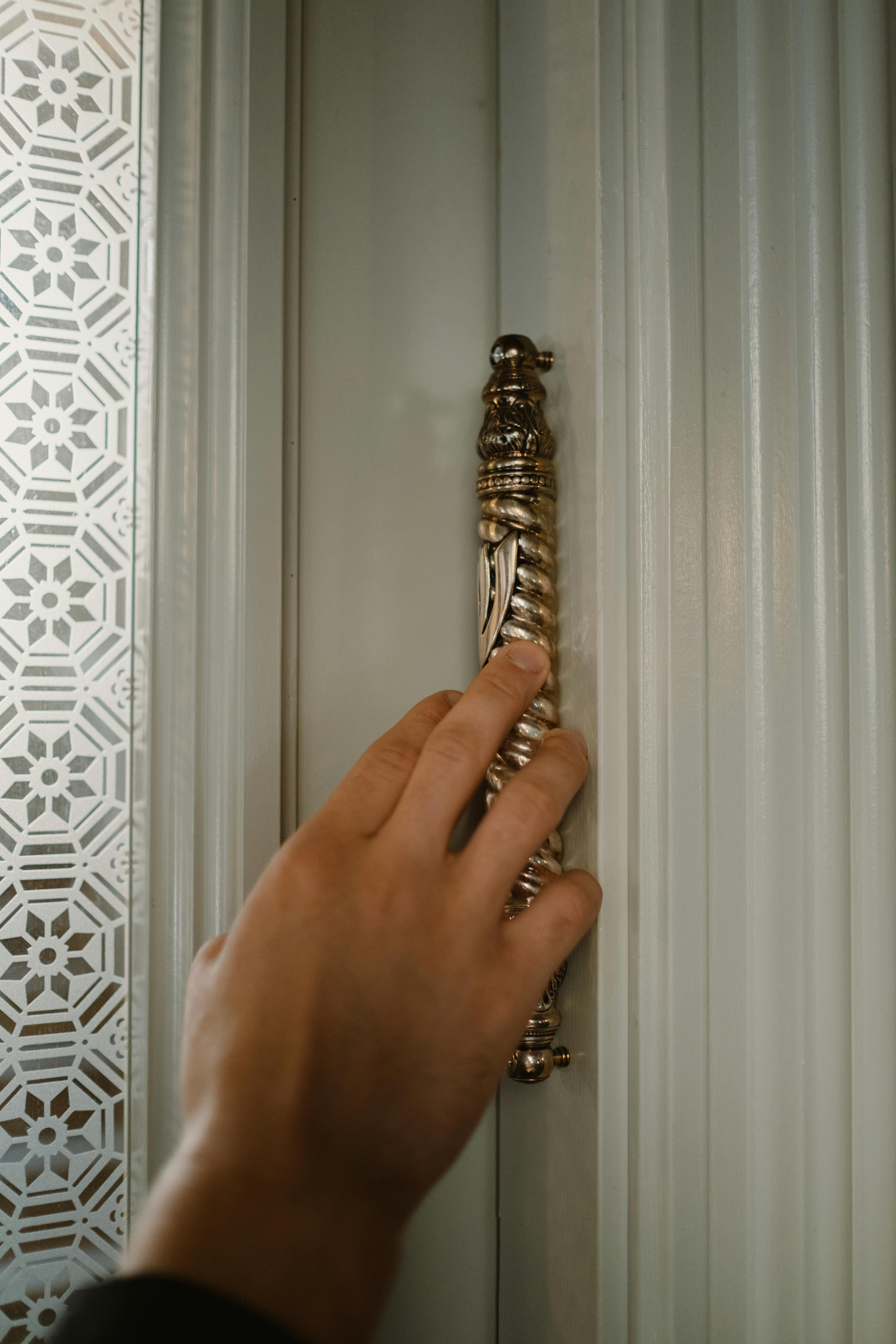 Close-up of Person Hand Touching Luxury Golden Doorpost · Free Stock Photo