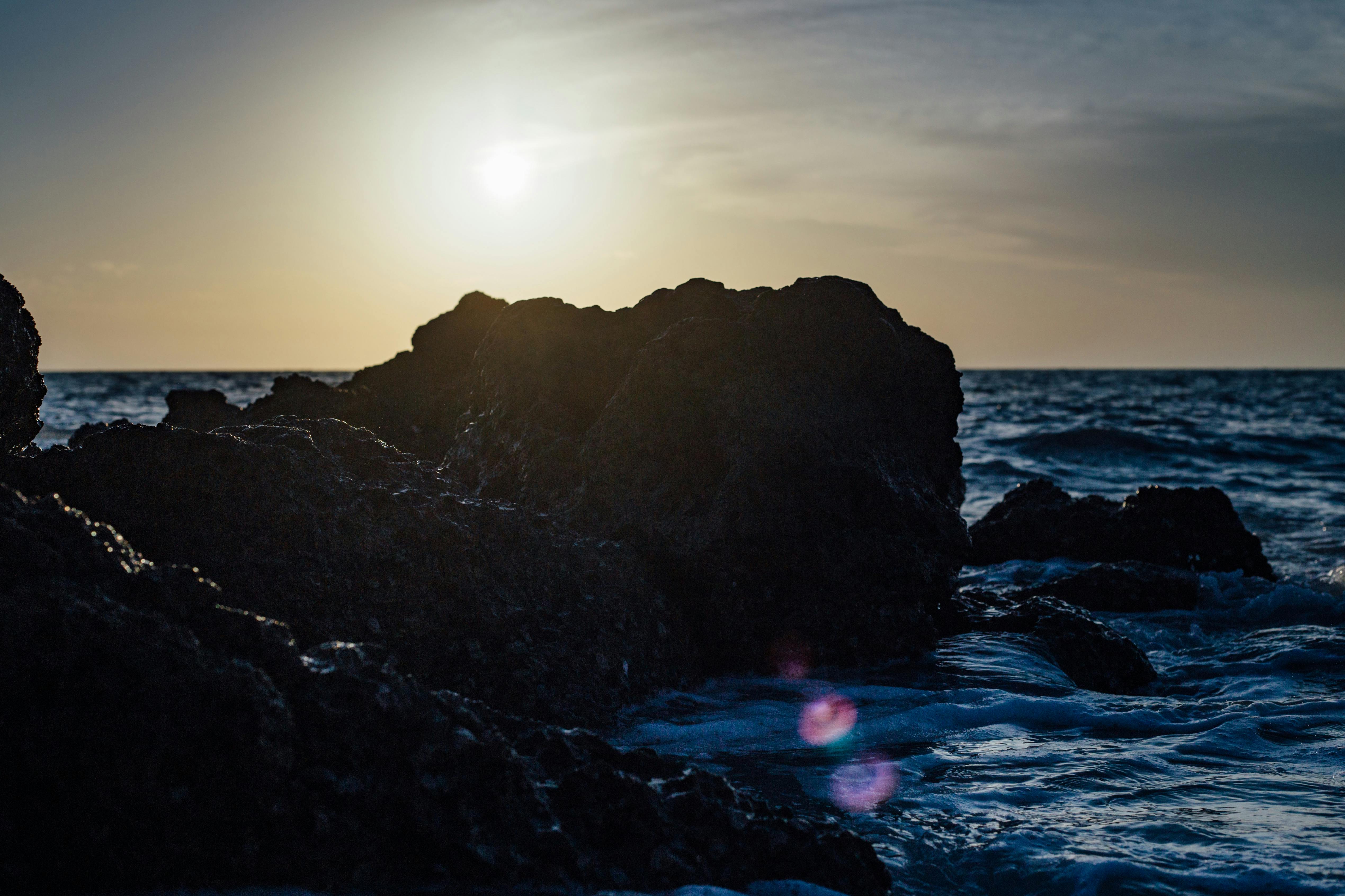 Black Stones on Sea Side during Sunset · Free Stock Photo