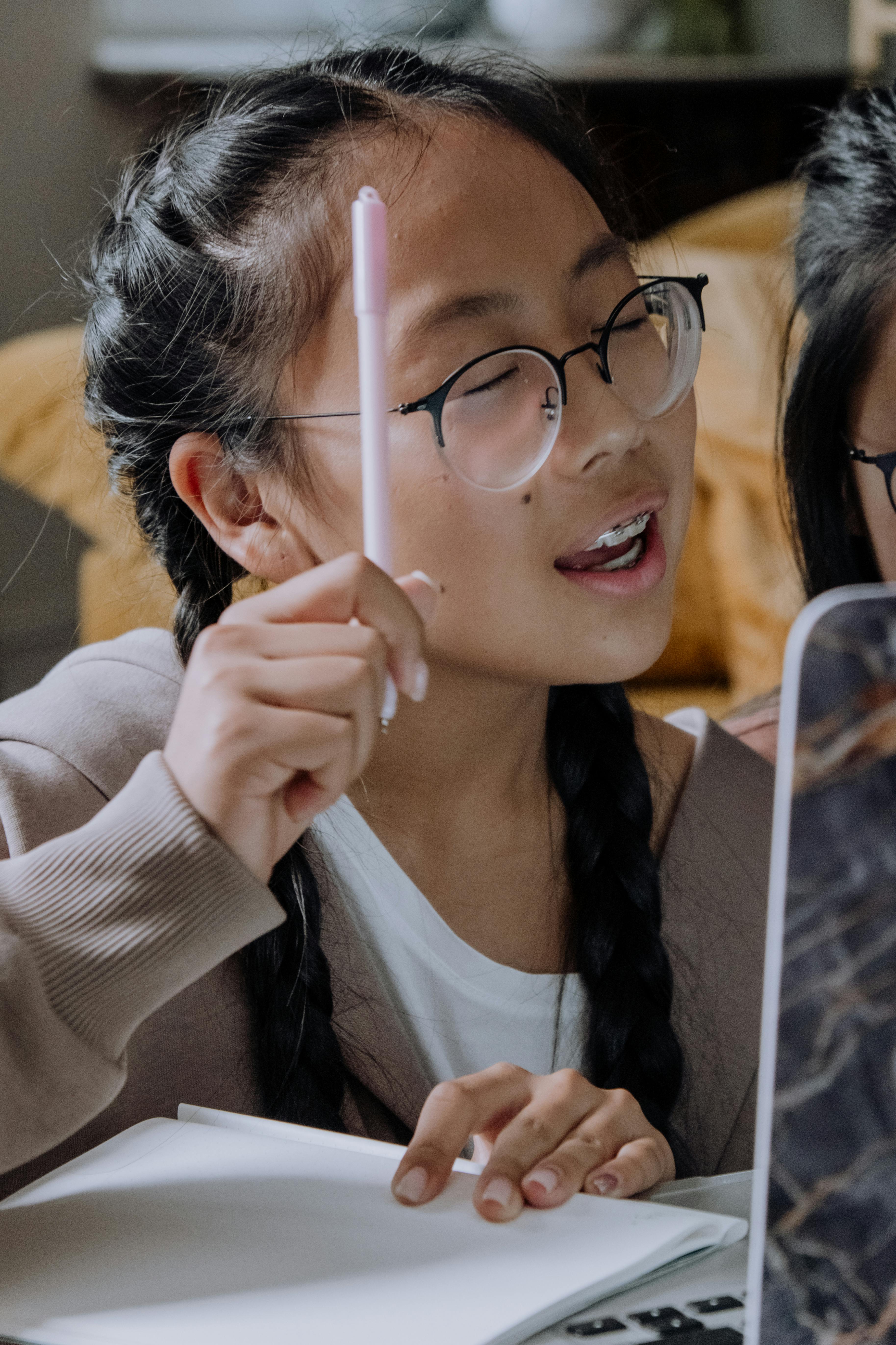 A Young Student Pondering at her Study Table · Free Stock Photo