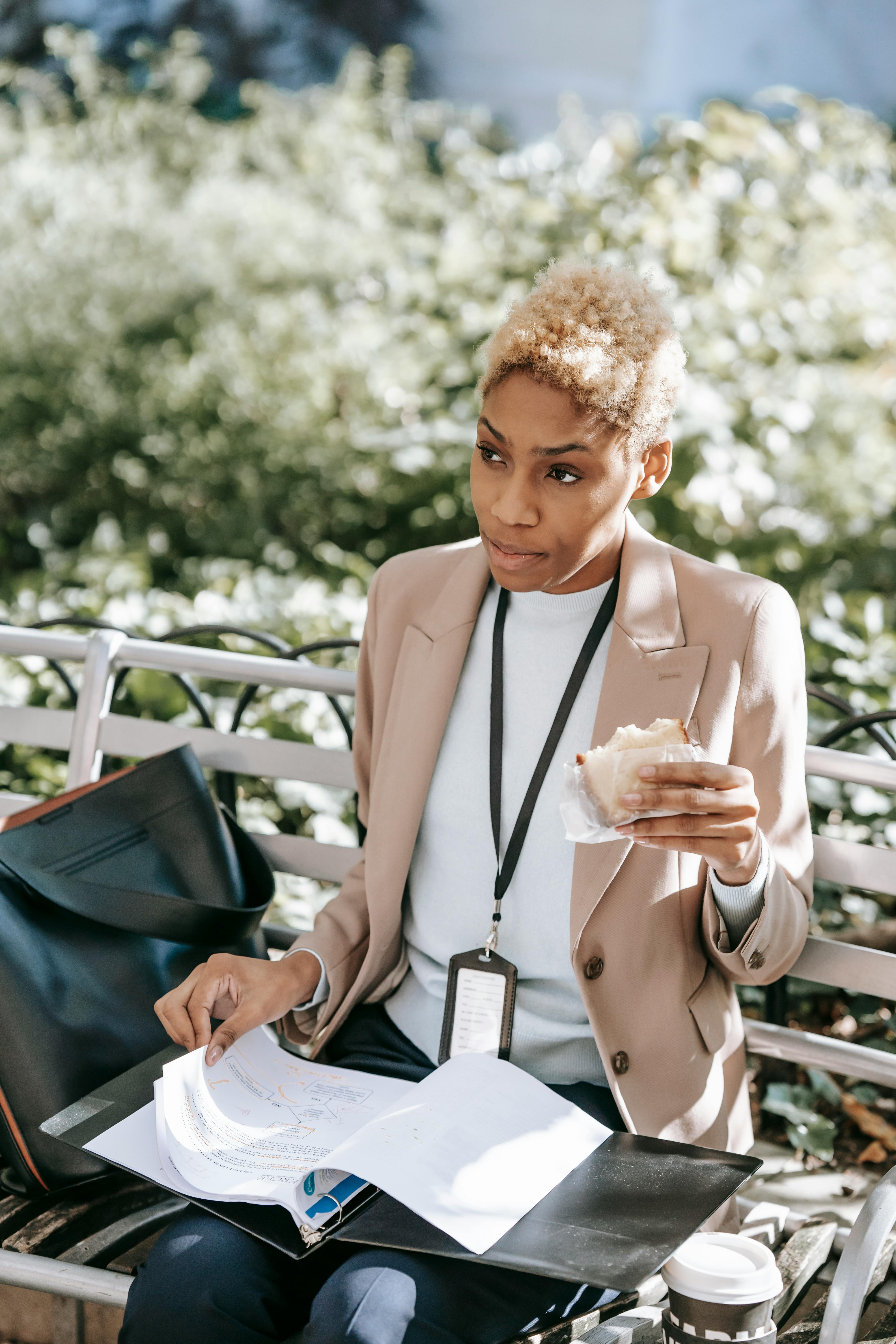 Calm woman eating sandwich and looking away · Free Stock Photo