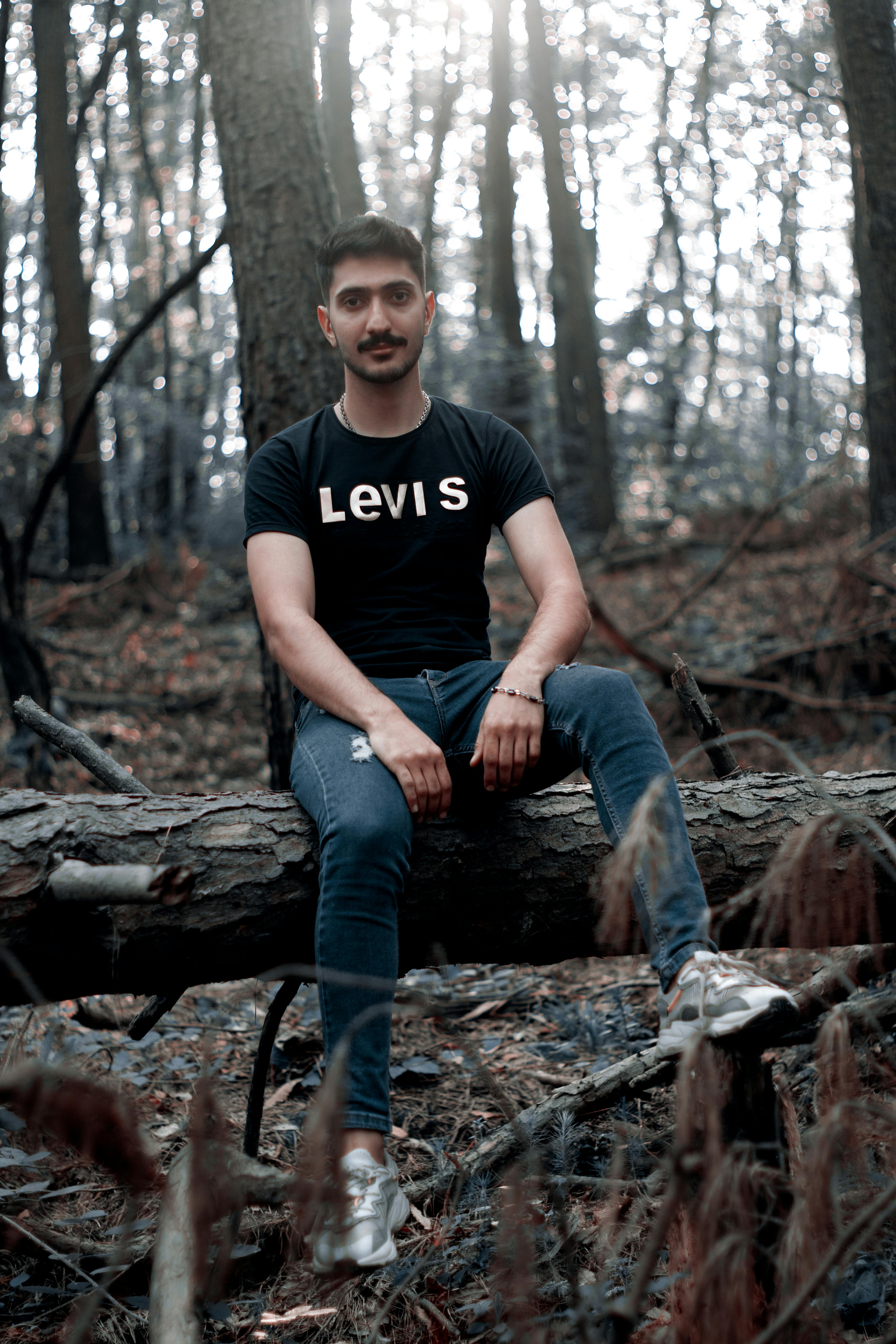 A Man Sitting on a Tree Log · Free Stock Photo