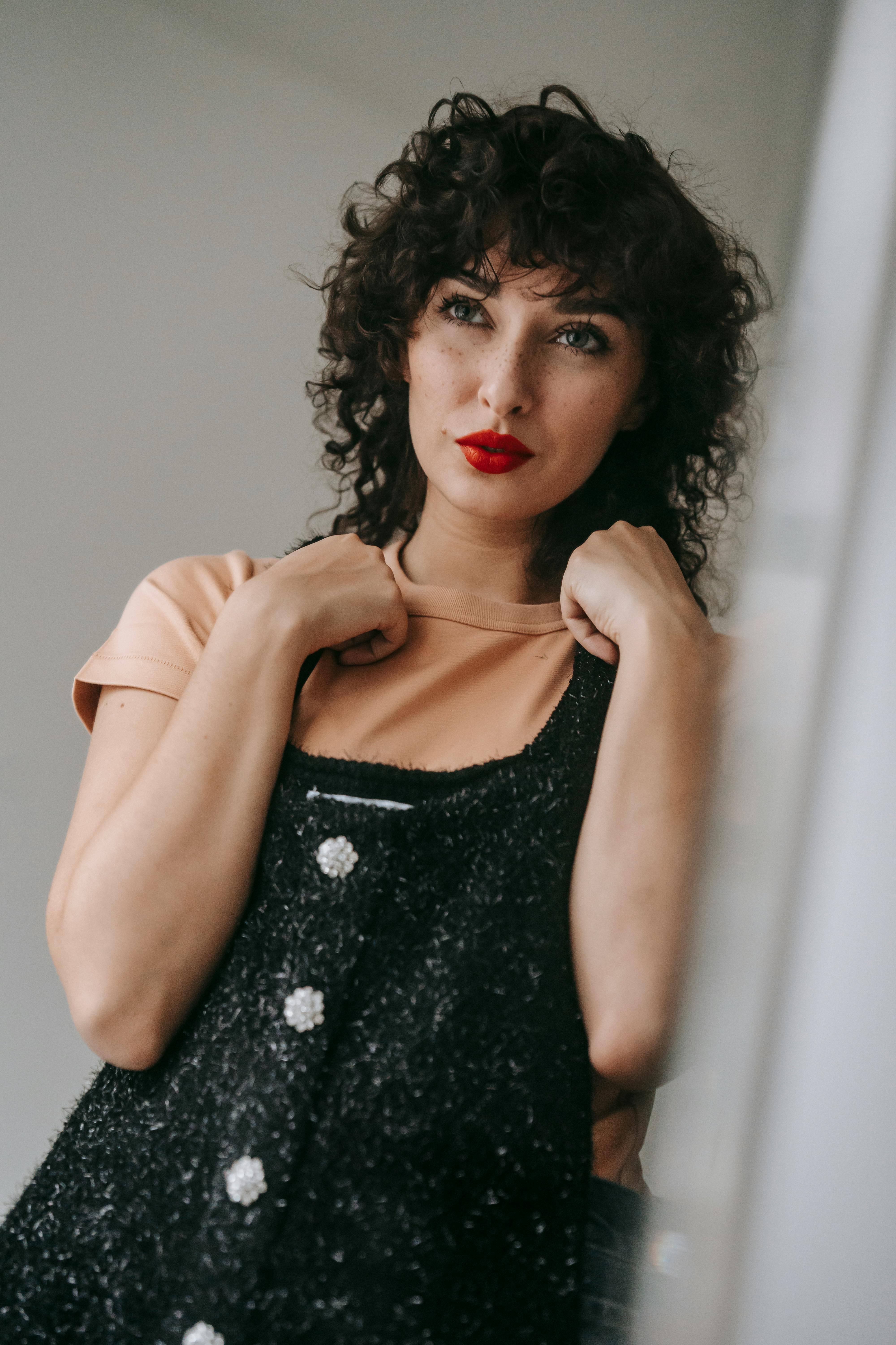 Charming woman choosing black dress to wear · Free Stock Photo