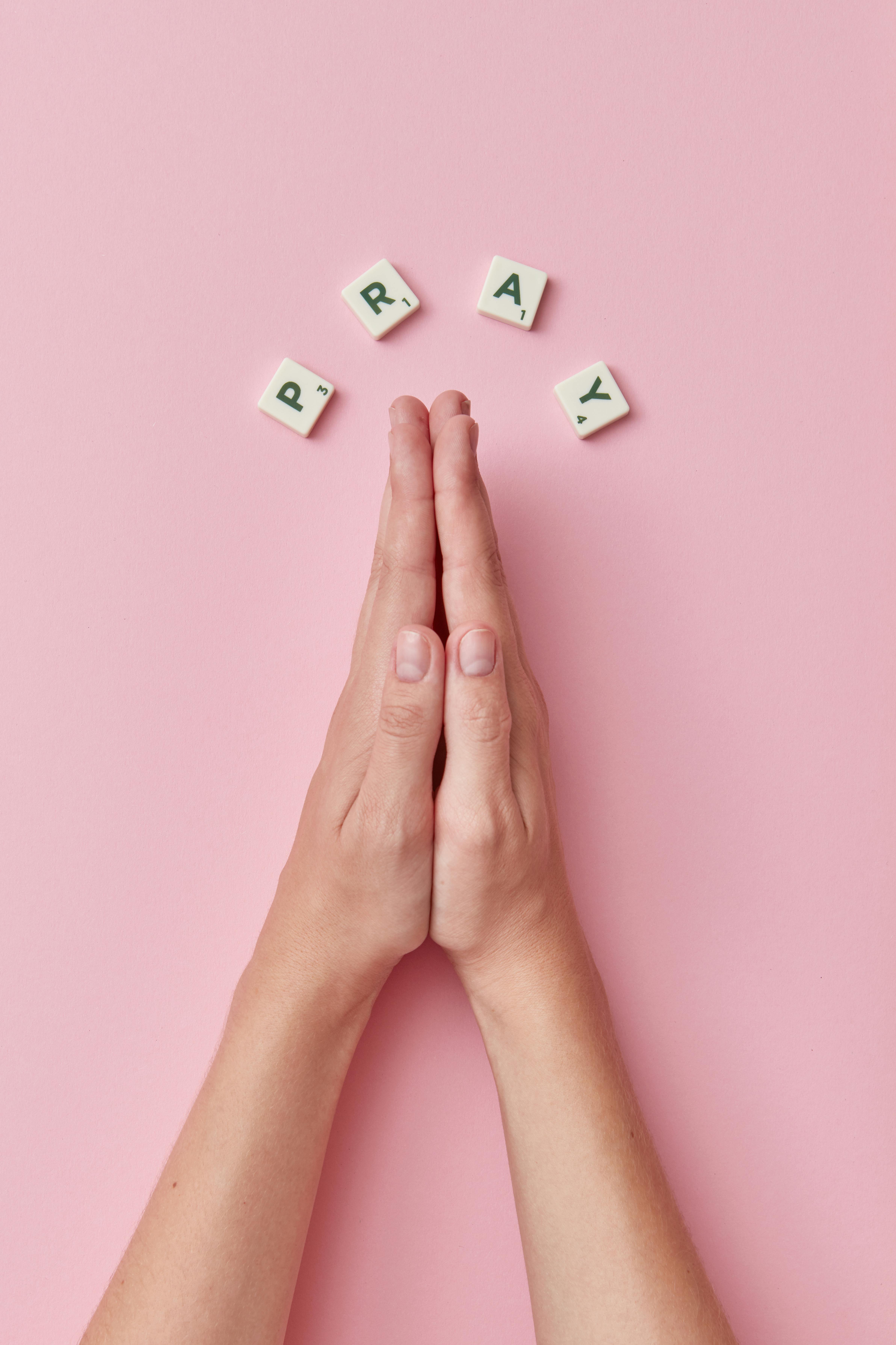 Person in Praying Hands on Pink Surface · Free Stock Photo