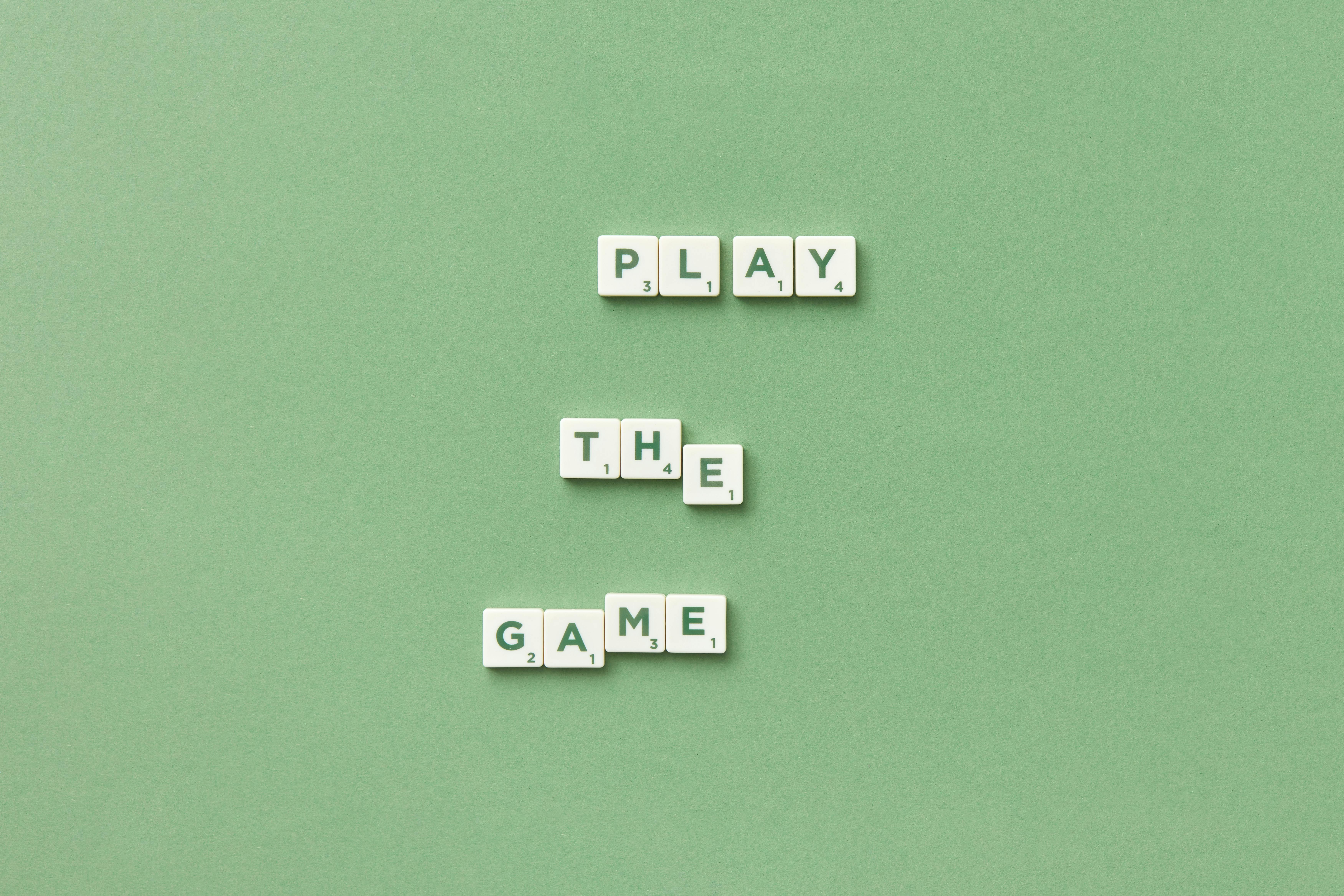 White Plastic Scrabble Tiles on Light Green Surface · Free Stock Photo