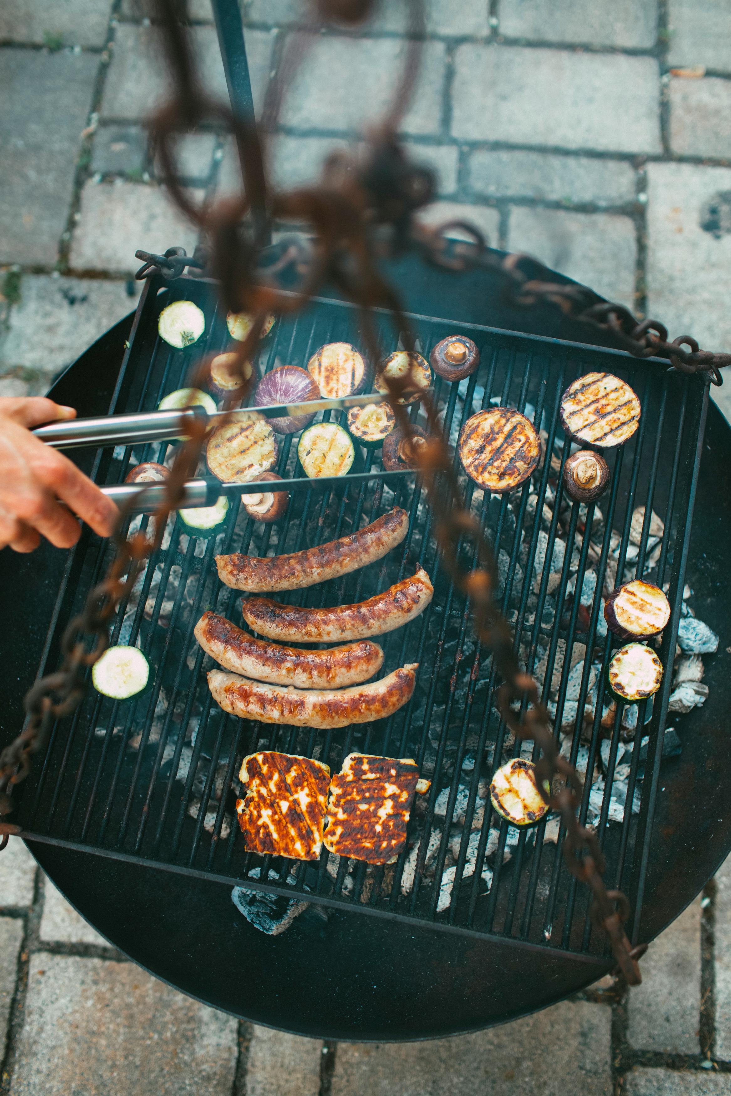 A Person Grilling Food on a Cast Iron Grill · Free Stock Photo