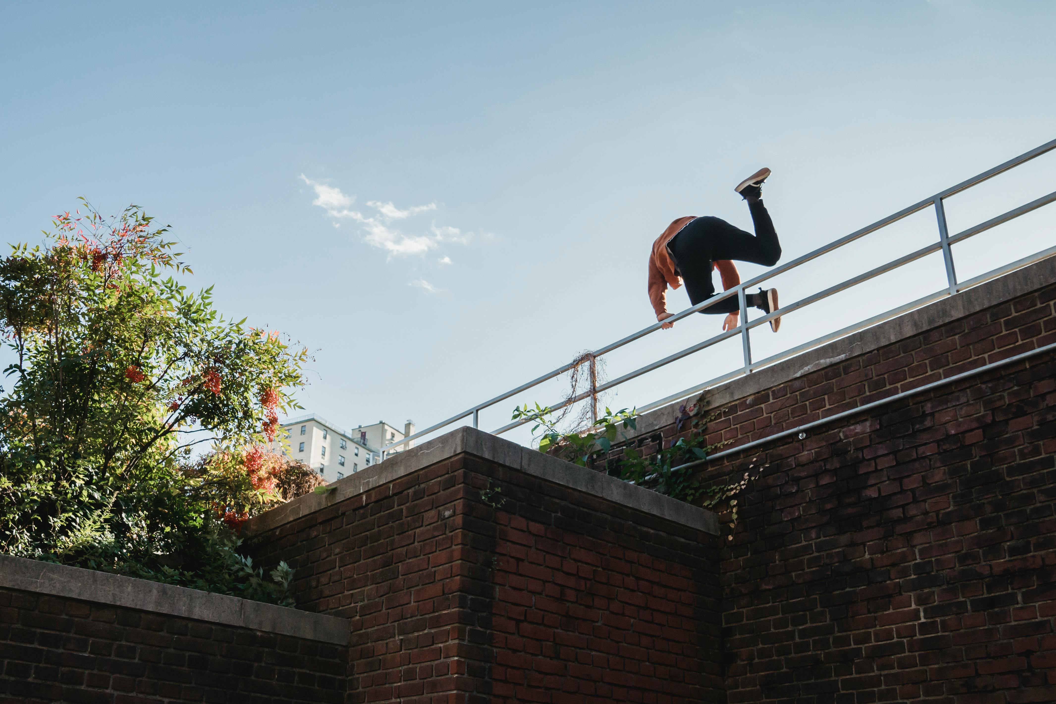 Fearless unrecognizable man jumping over railing · Free Stock Photo