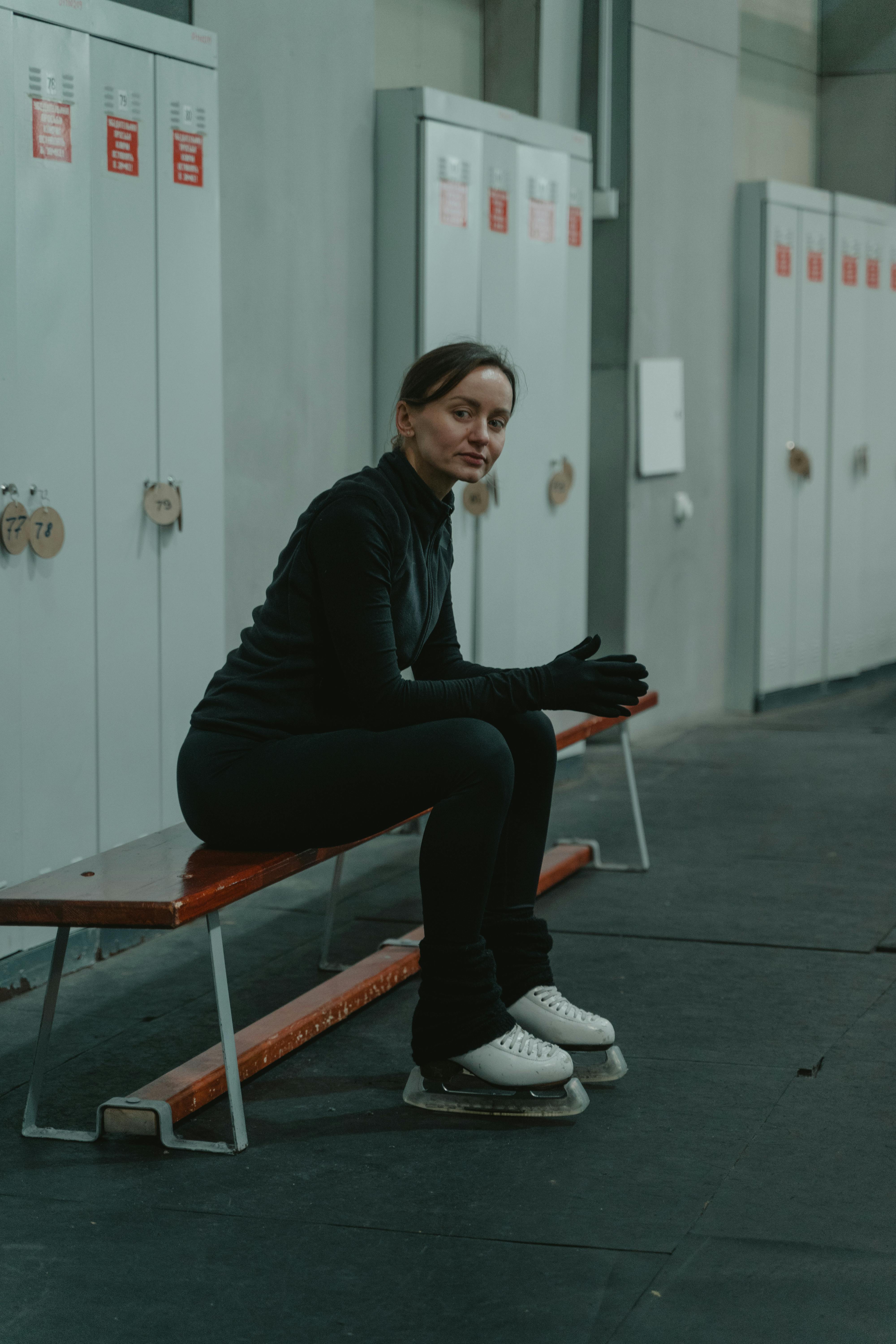 Woman in Black Clothes Wearing Ice Skating Shoes Sitting on Bench ...