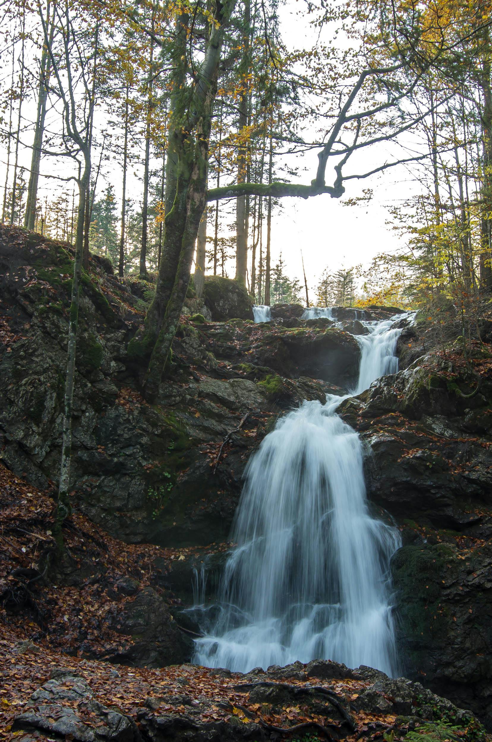 People Standing Near Waterfalls Cascading from Mountain · Free Stock Photo