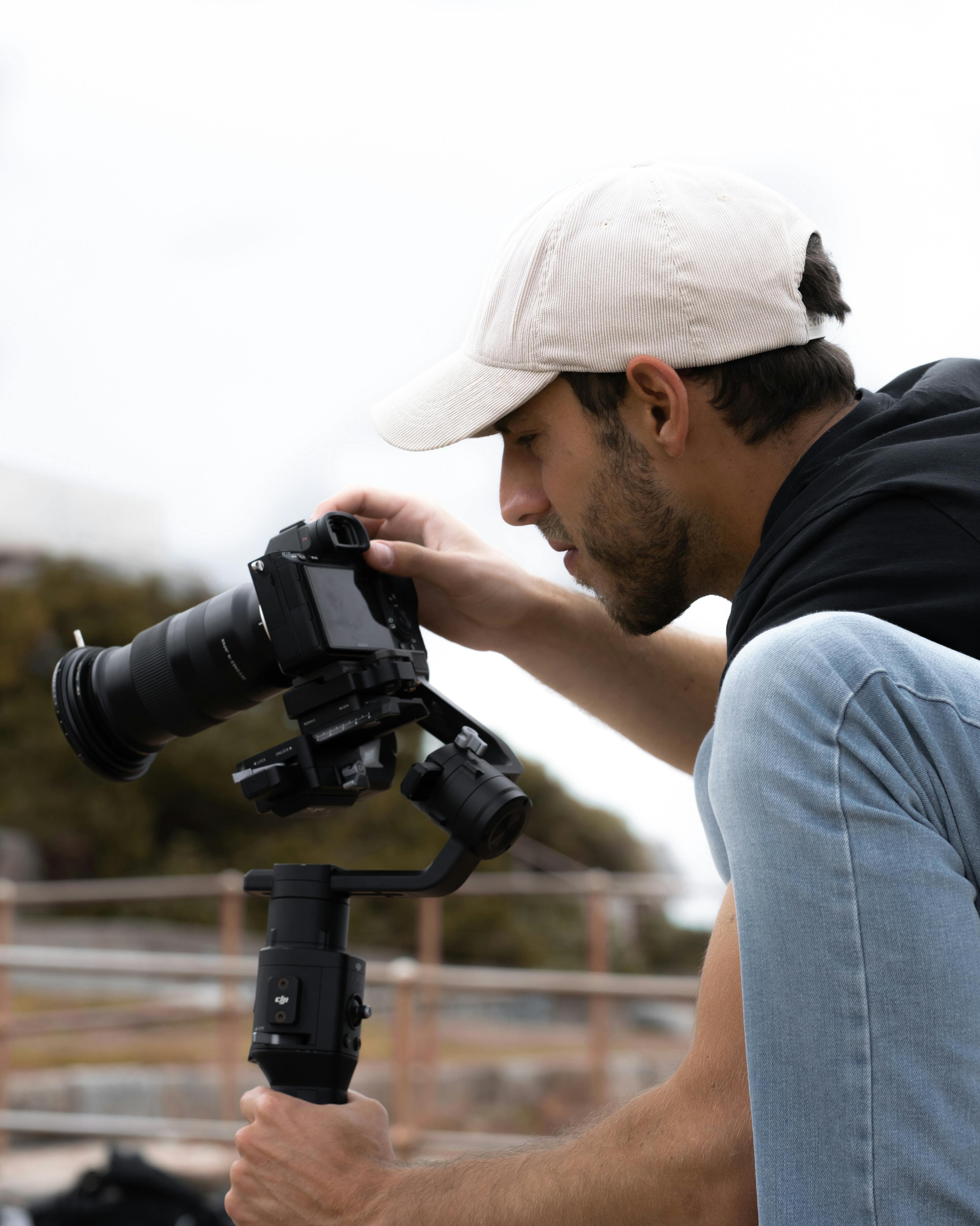 Man with Professional Camera Filming Outdoors · Free Stock Photo