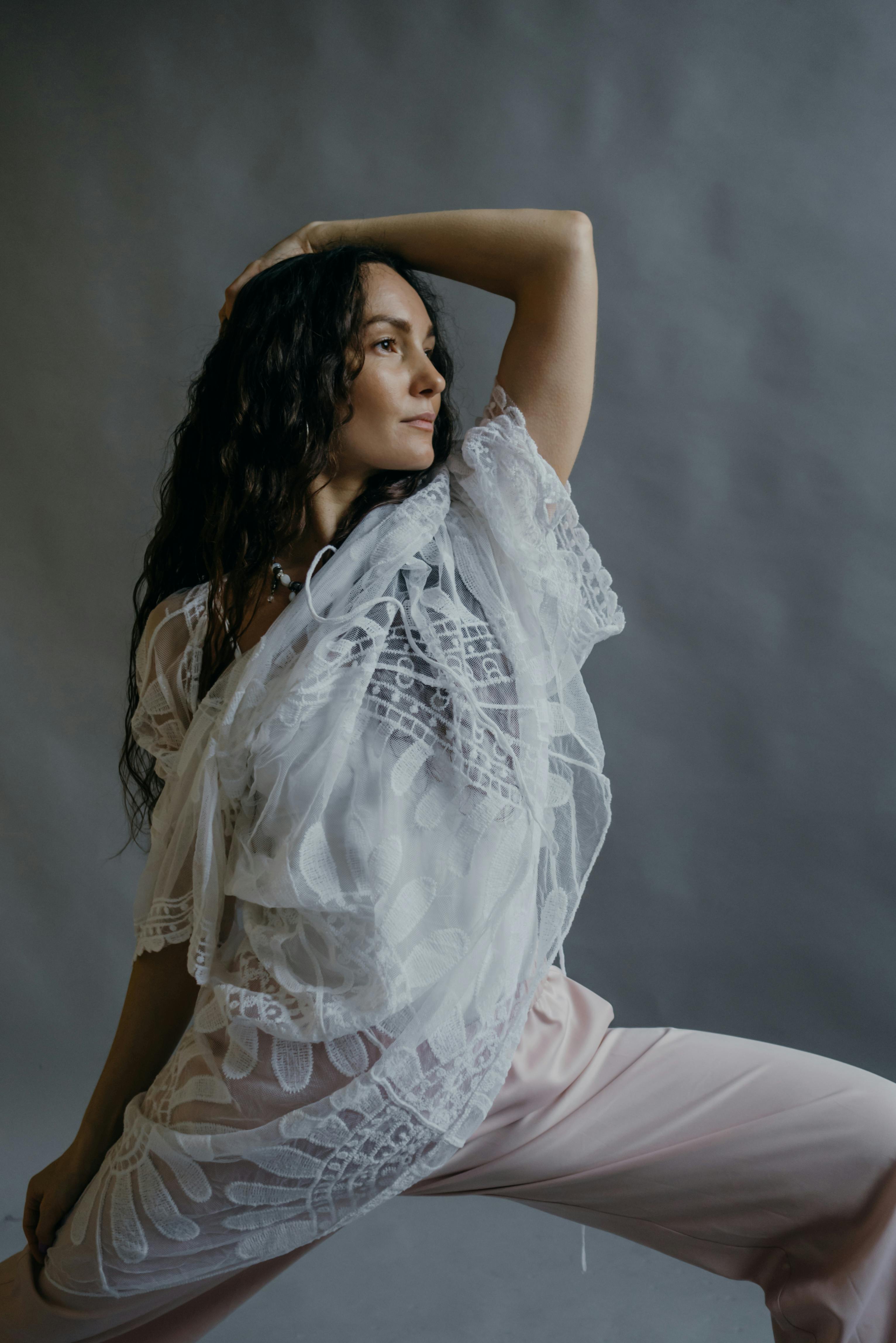 A Woman Holding her Head while Posing in a Studio · Free Stock Photo