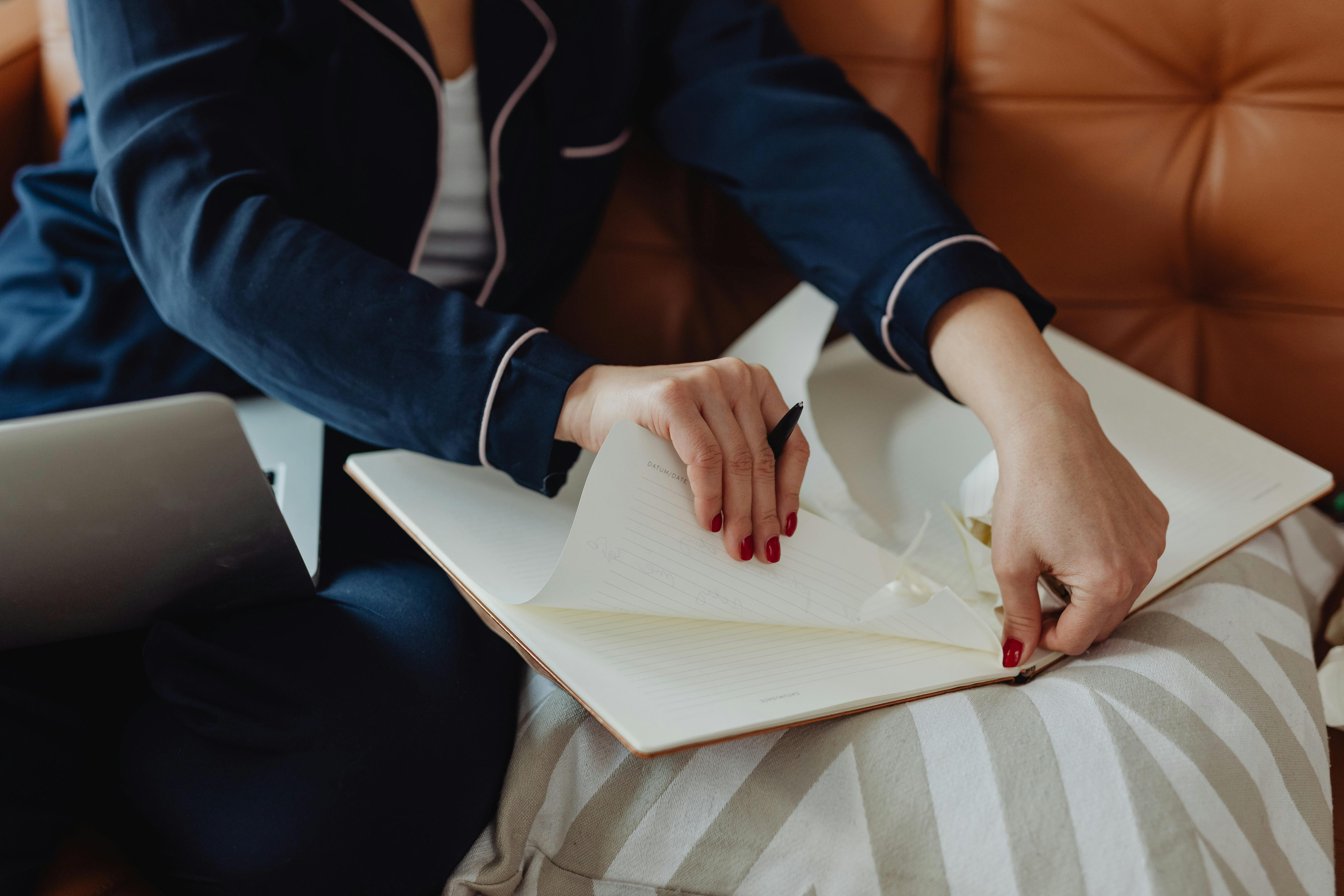 Person with Red Nails Tearing a Notebook · Free Stock Photo