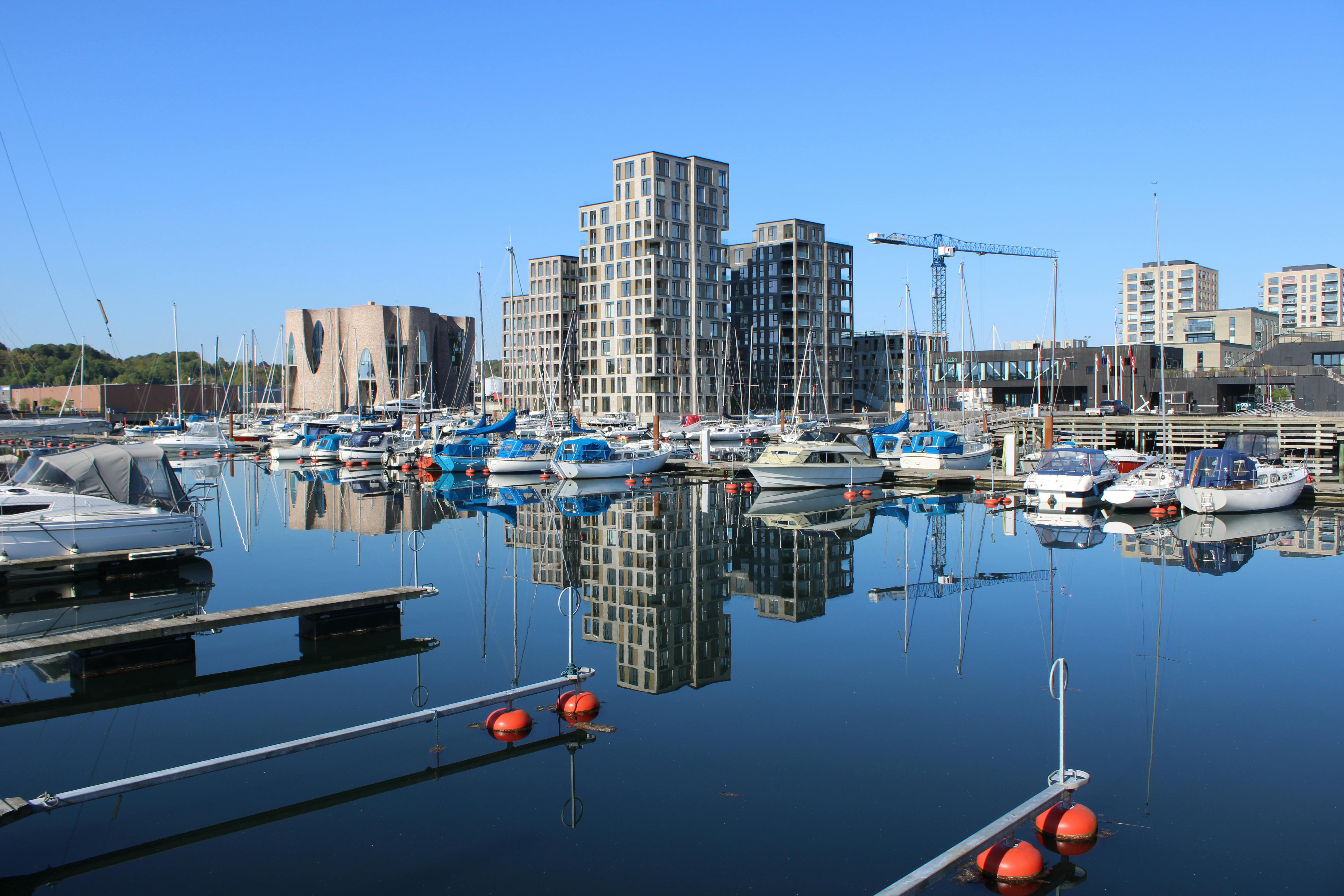 Various Watercrafts on Docking Area Near City Buildings · Free Stock Photo