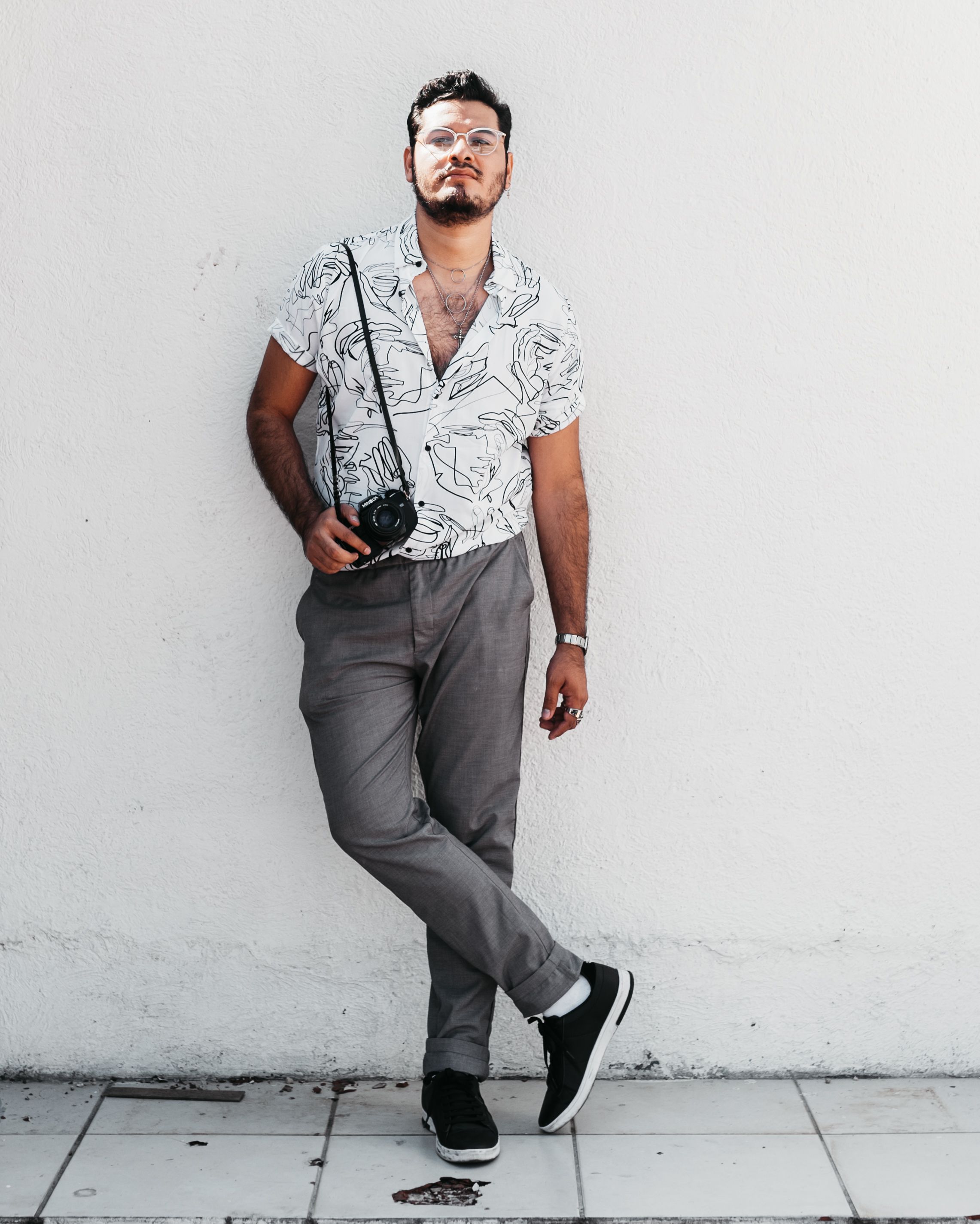 Serious man standing near wall · Free Stock Photo