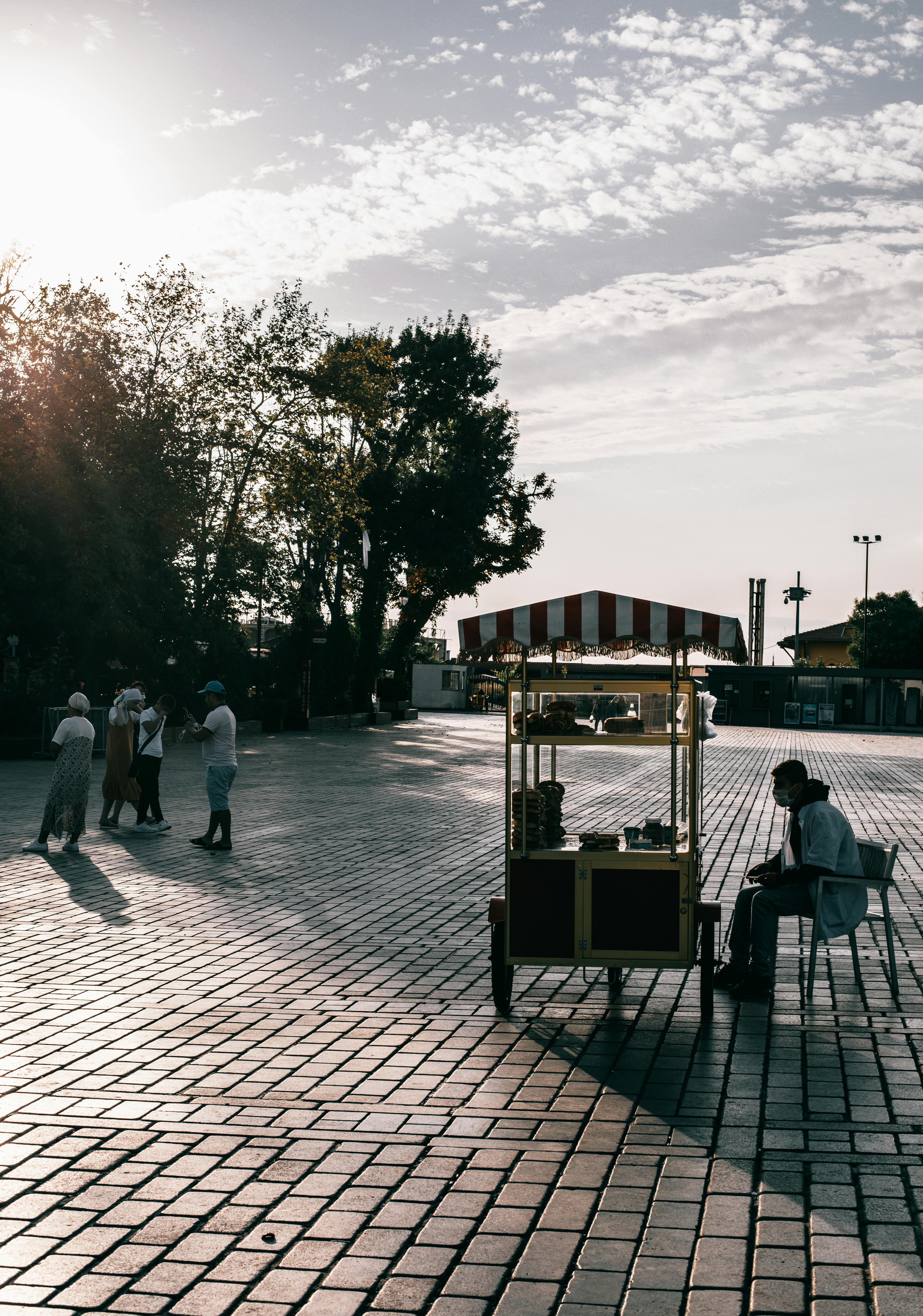 A Vendor Selling Food Using a Cart on the Street · Free Stock Photo