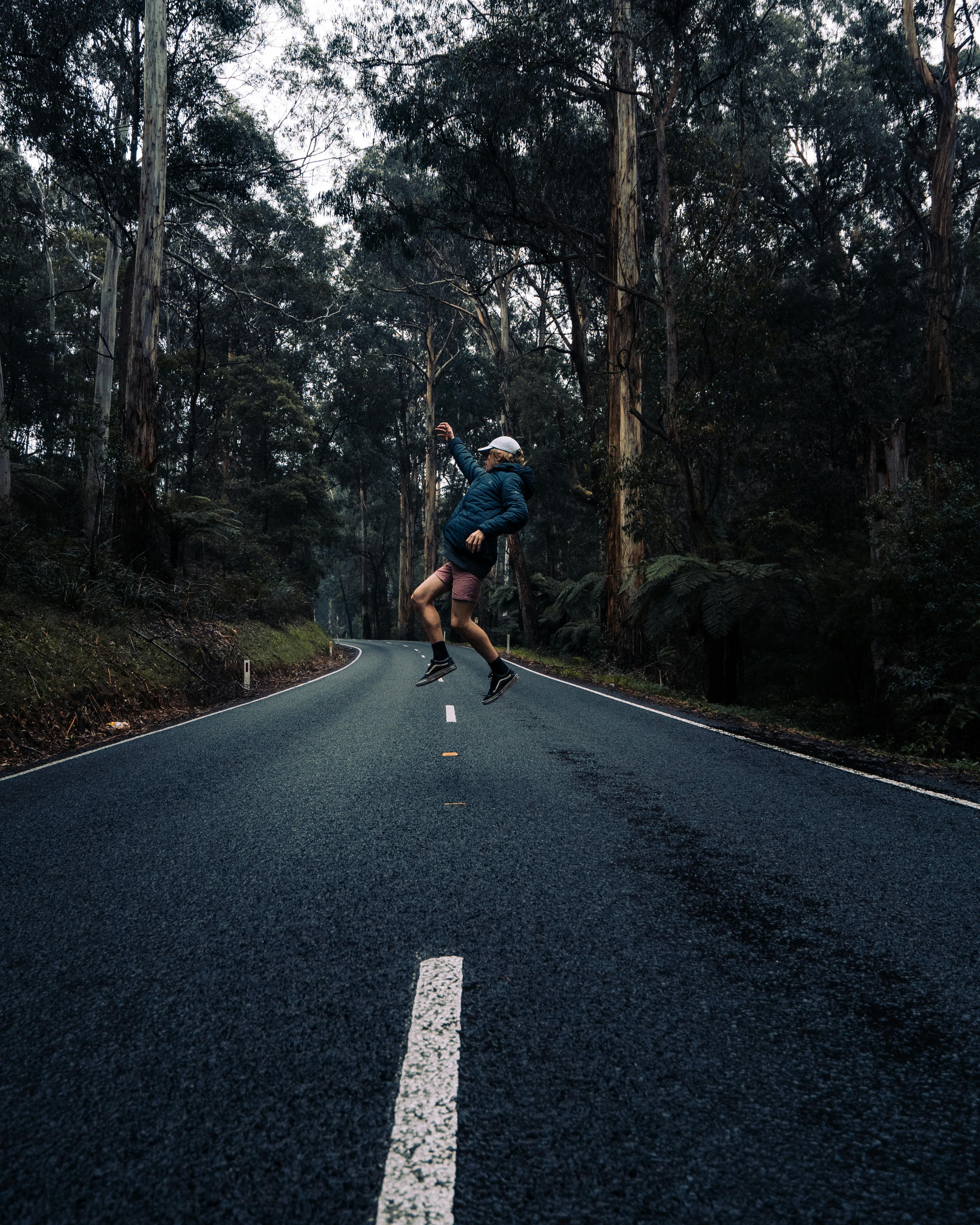 A Man Jumping in the Middle of the Road · Free Stock Photo