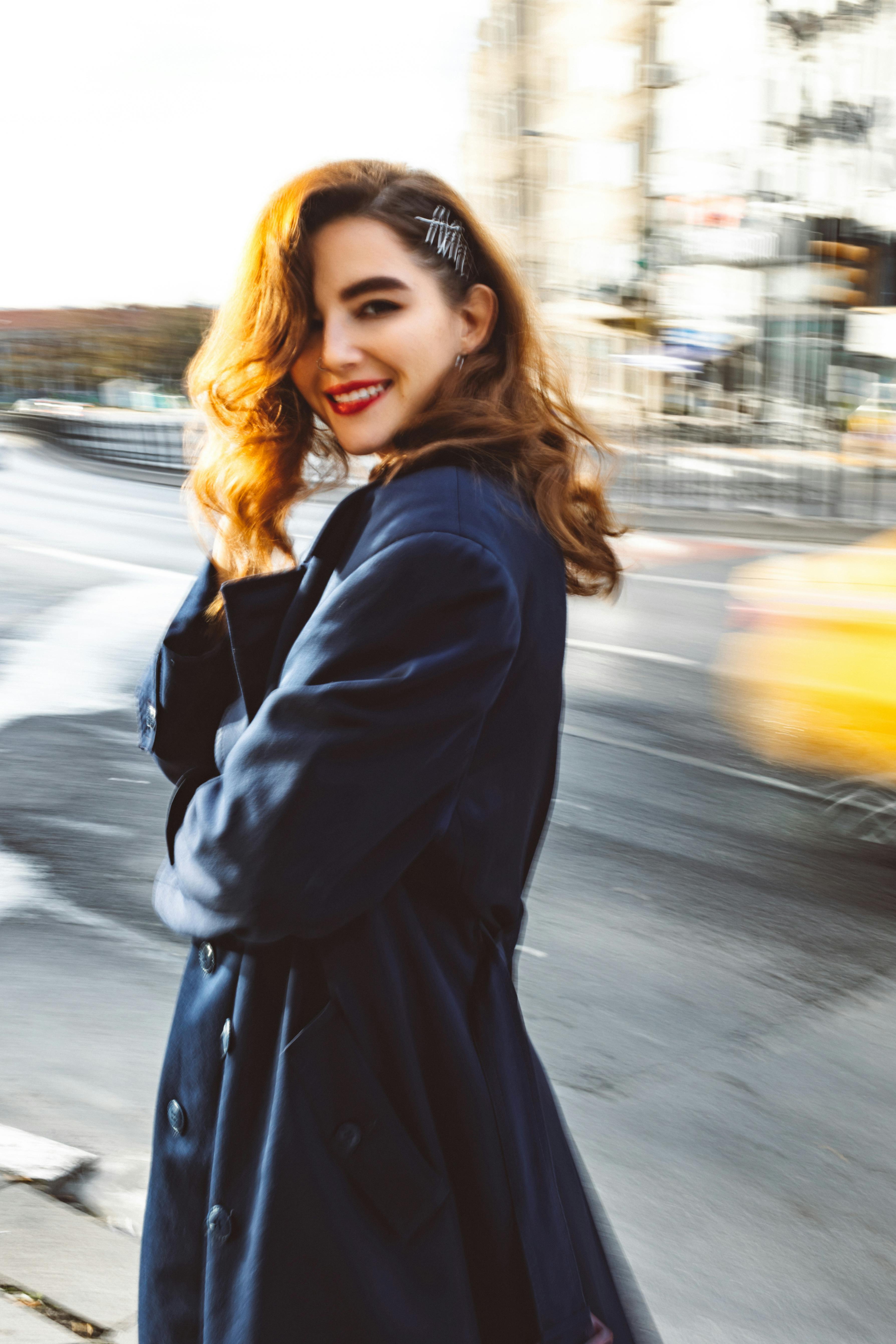 Woman in Red Coat Sitting on Bus Stop with People Passing By · Free ...