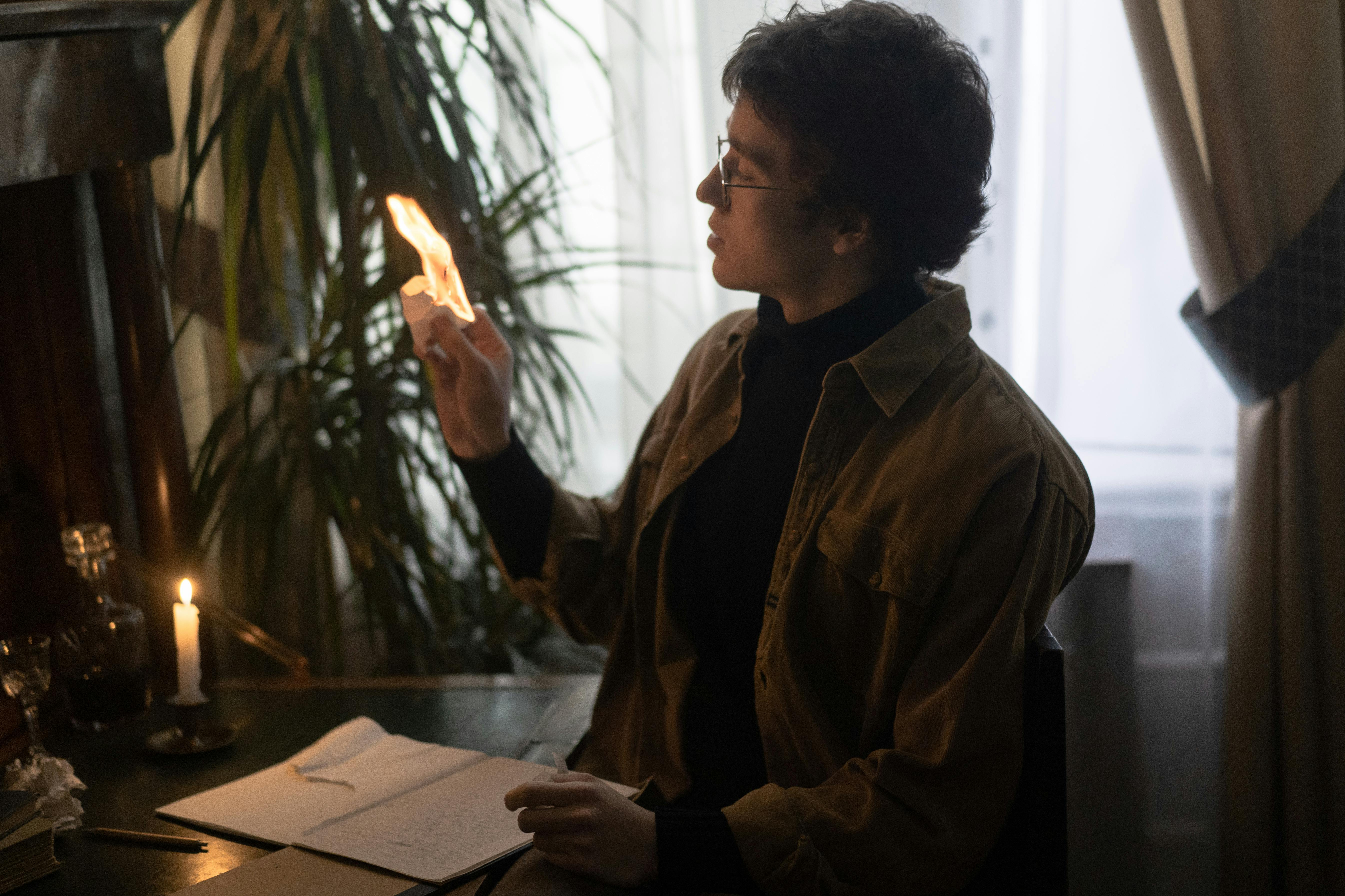Man Holding a Burning Paper · Free Stock Photo