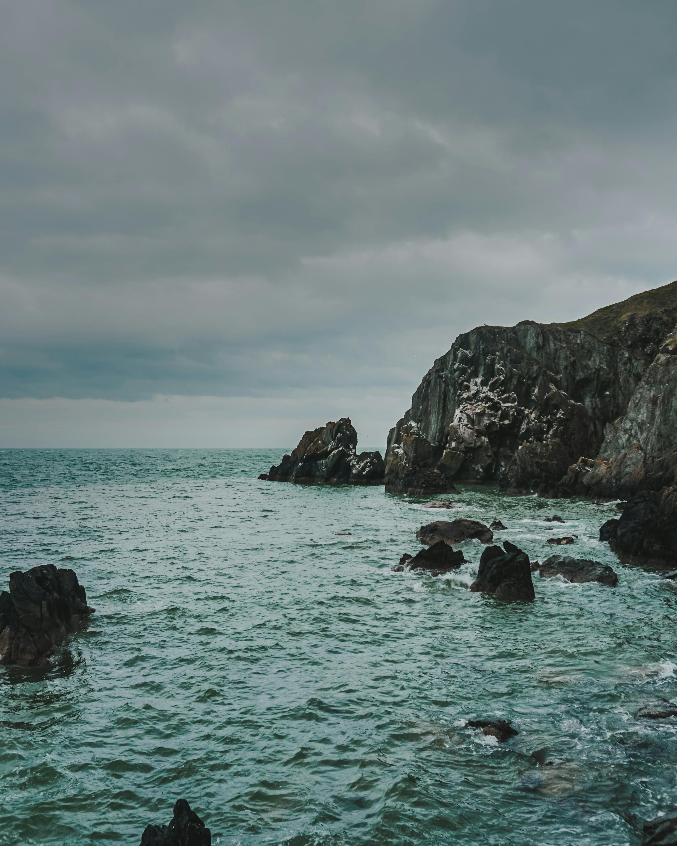 Brown Concrete Building Near Sea Under Cloudy Sky · Free Stock Photo
