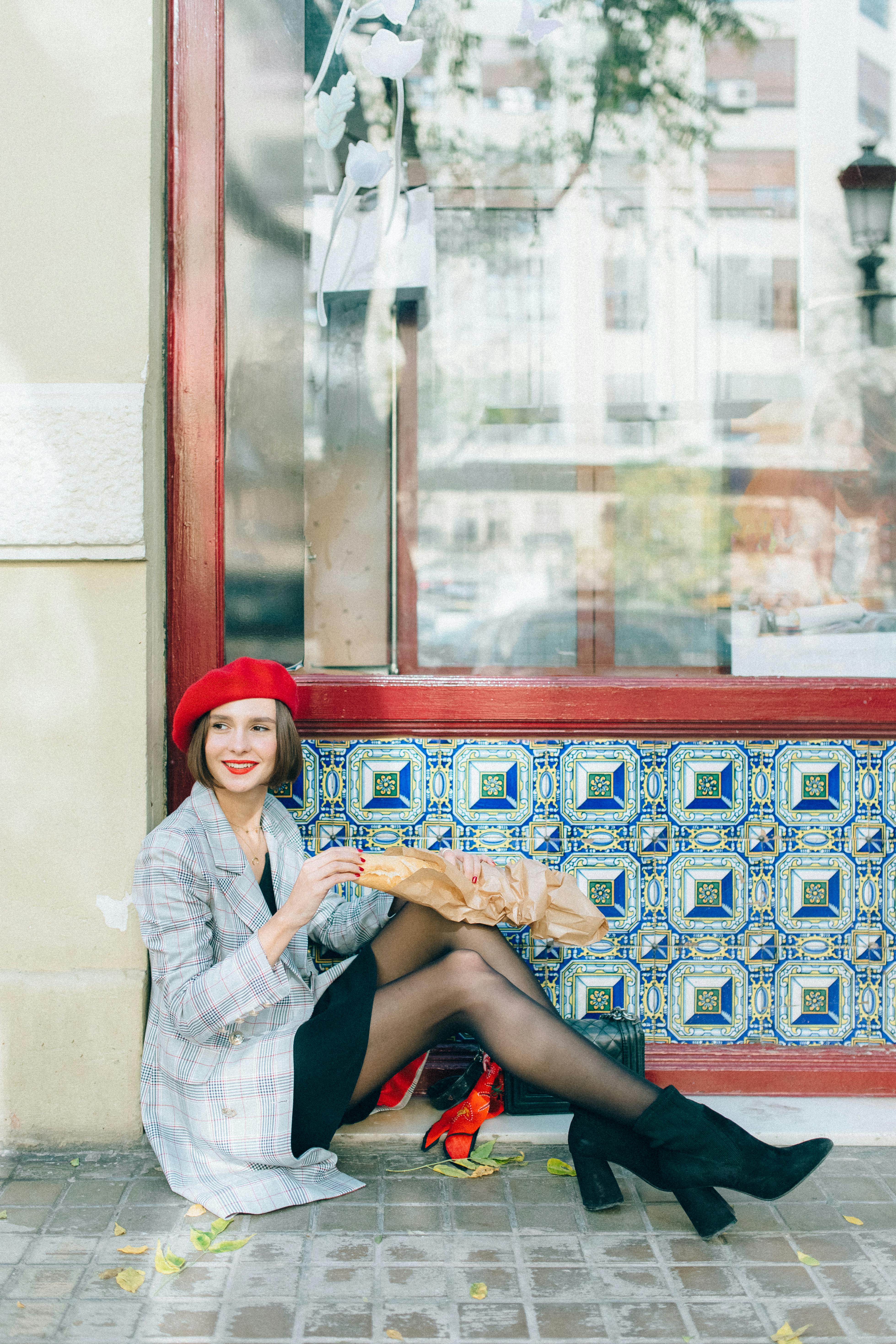 A Woman Sitting on the Floor While Holding a Long Paper Bag · Free ...