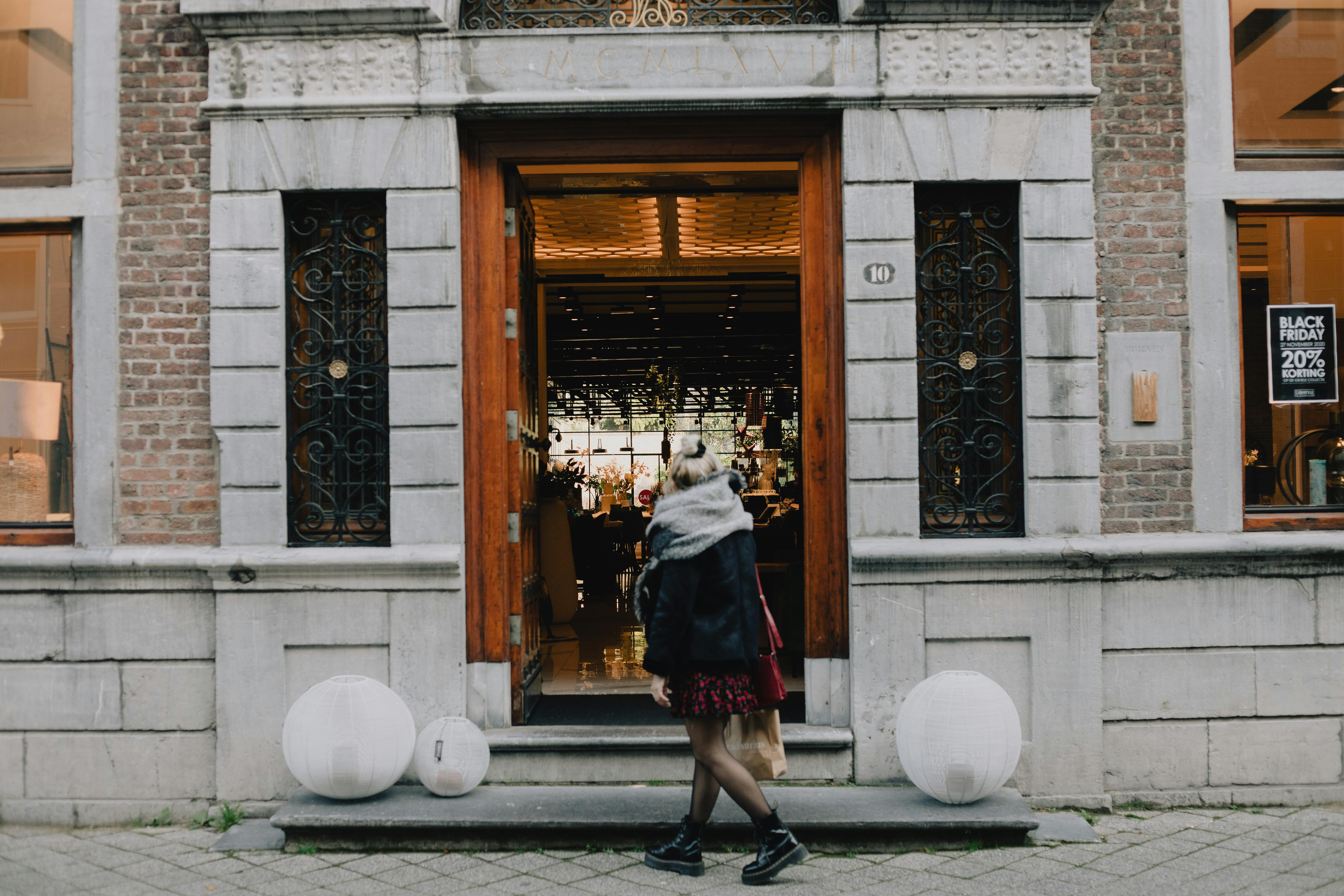 A Person Walking by a Storefront · Free Stock Photo