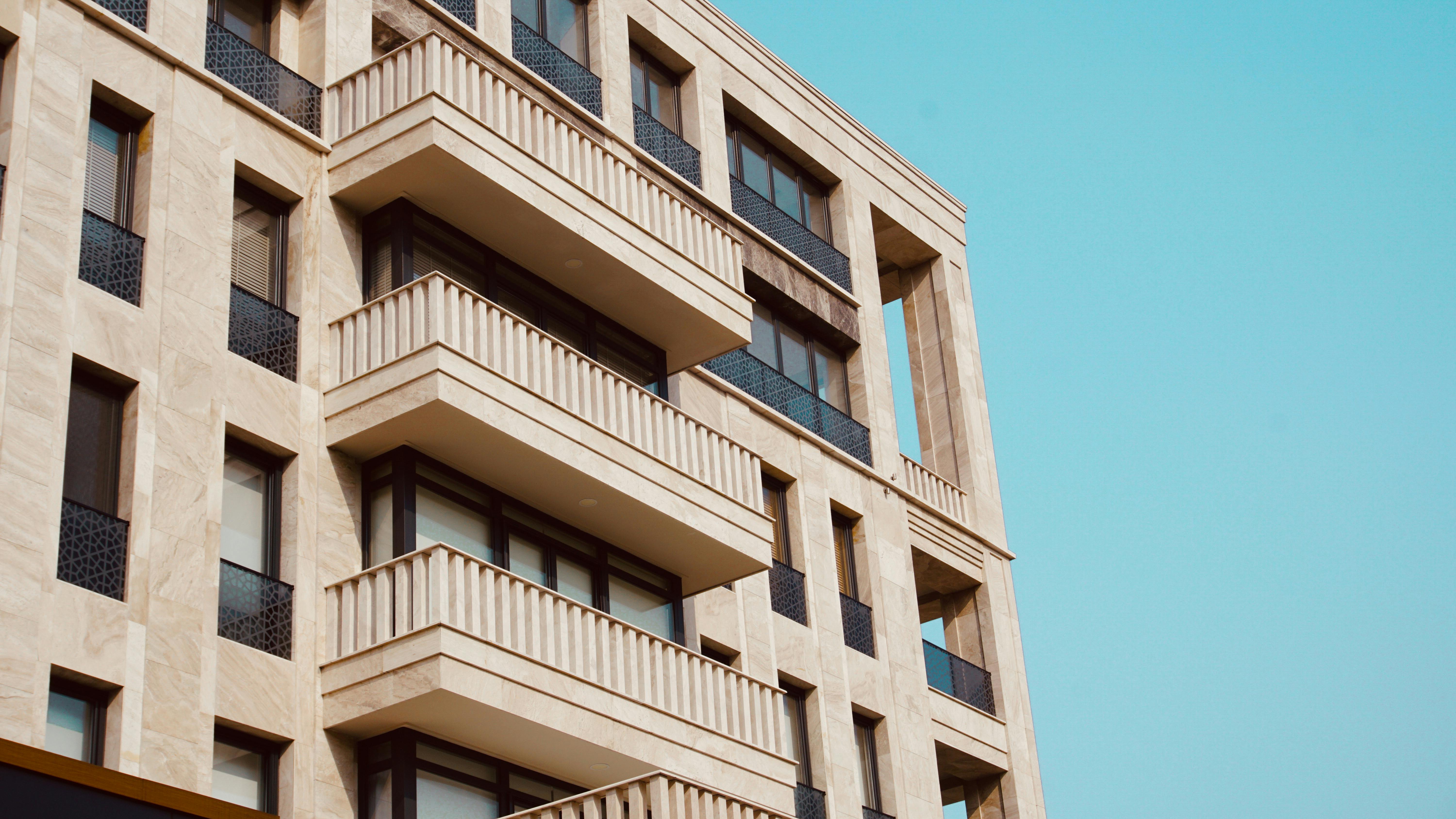 Concrete Building With Balconies Under Clear Blue Sky · Free Stock Photo
