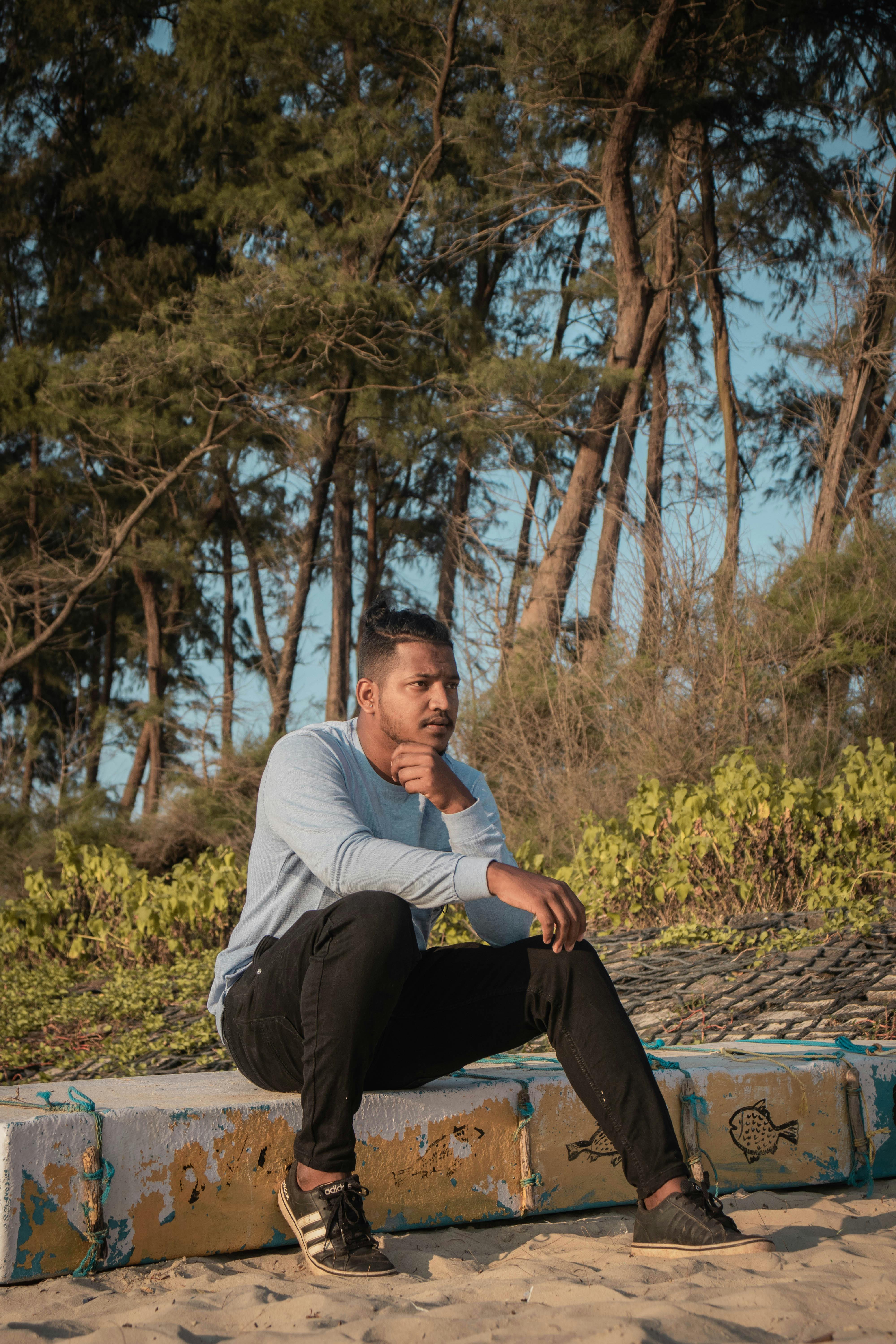 Portrait of Man Sitting near Trees · Free Stock Photo