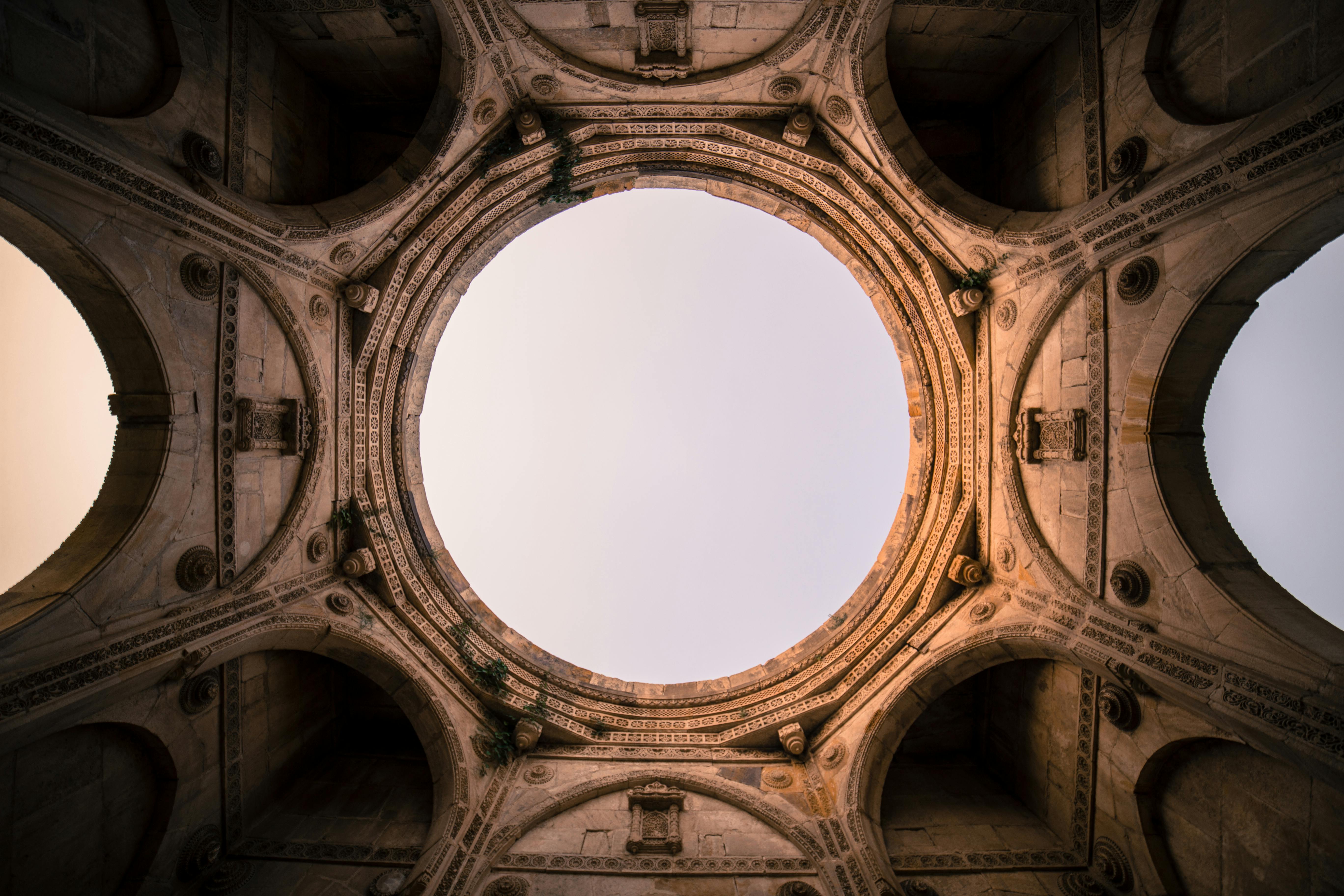 Round Opening Surrounded With Arches on Stone Walls · Free Stock Photo