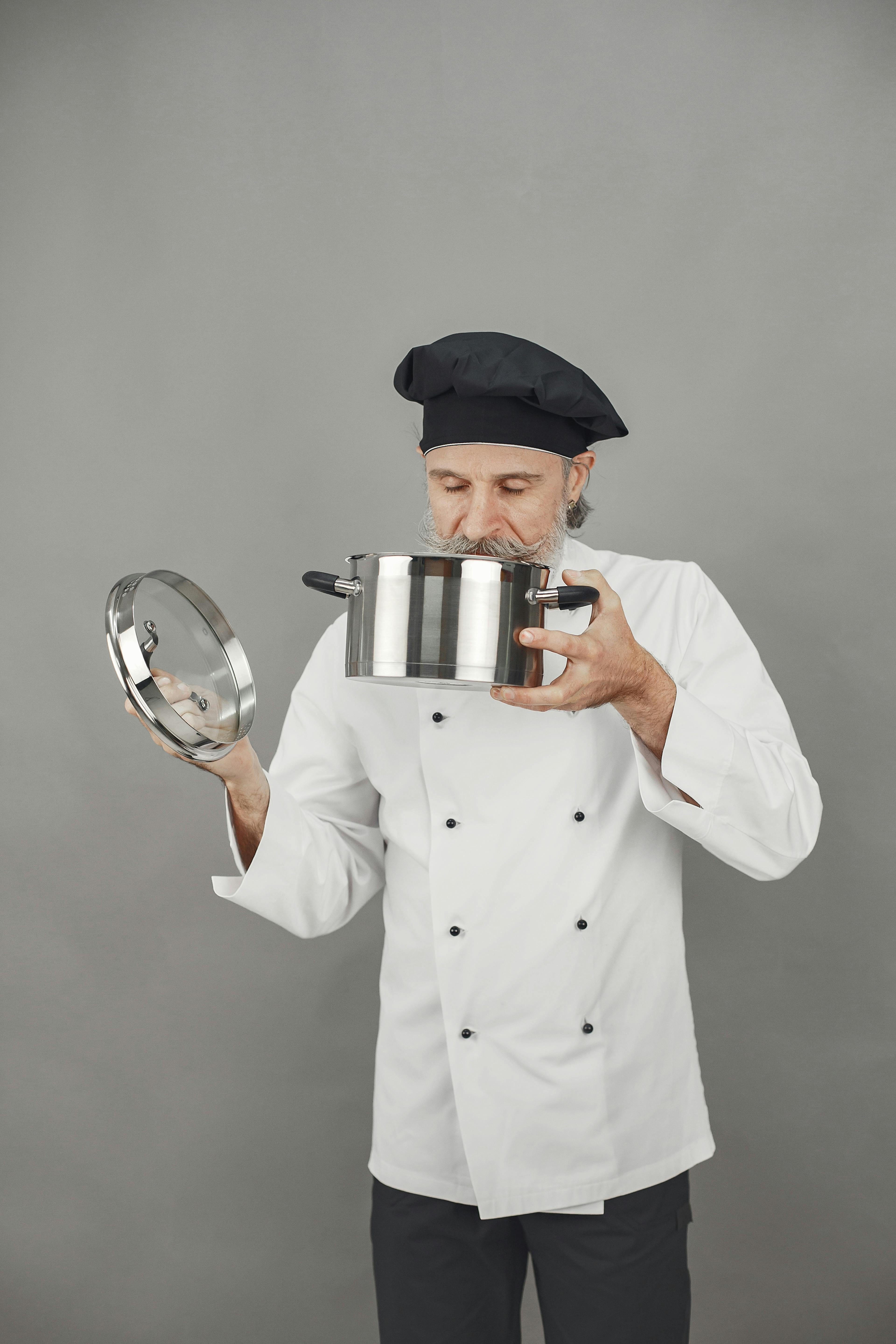 A Man Smelling the Food in the Stainless Steel Soup Pot · Free Stock Photo