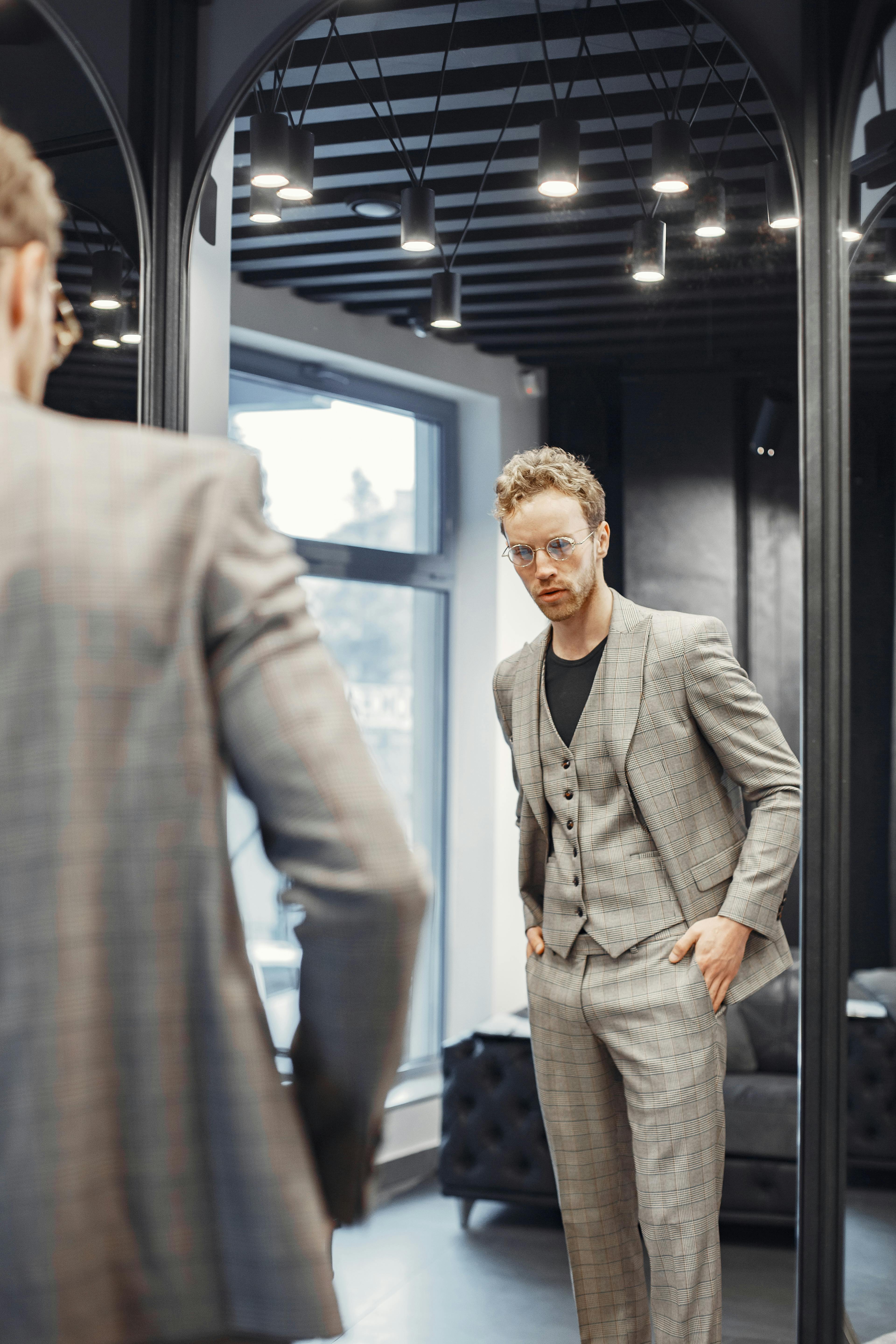 Man in Gray Suit Standing in Front of a Mirror · Free Stock Photo