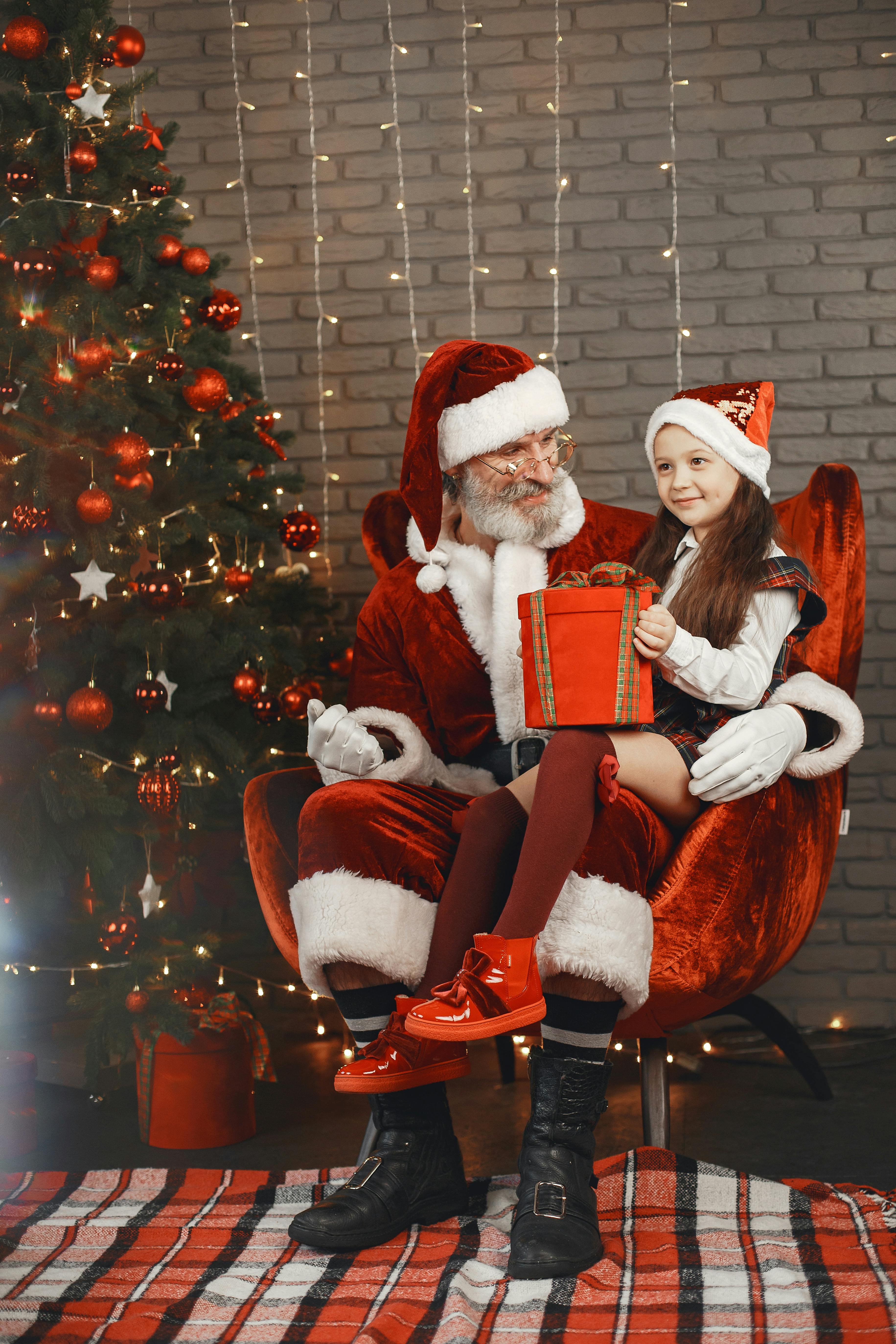 Girl with a Christmas Gift Sitting on the Lap of Santa Claus · Free ...