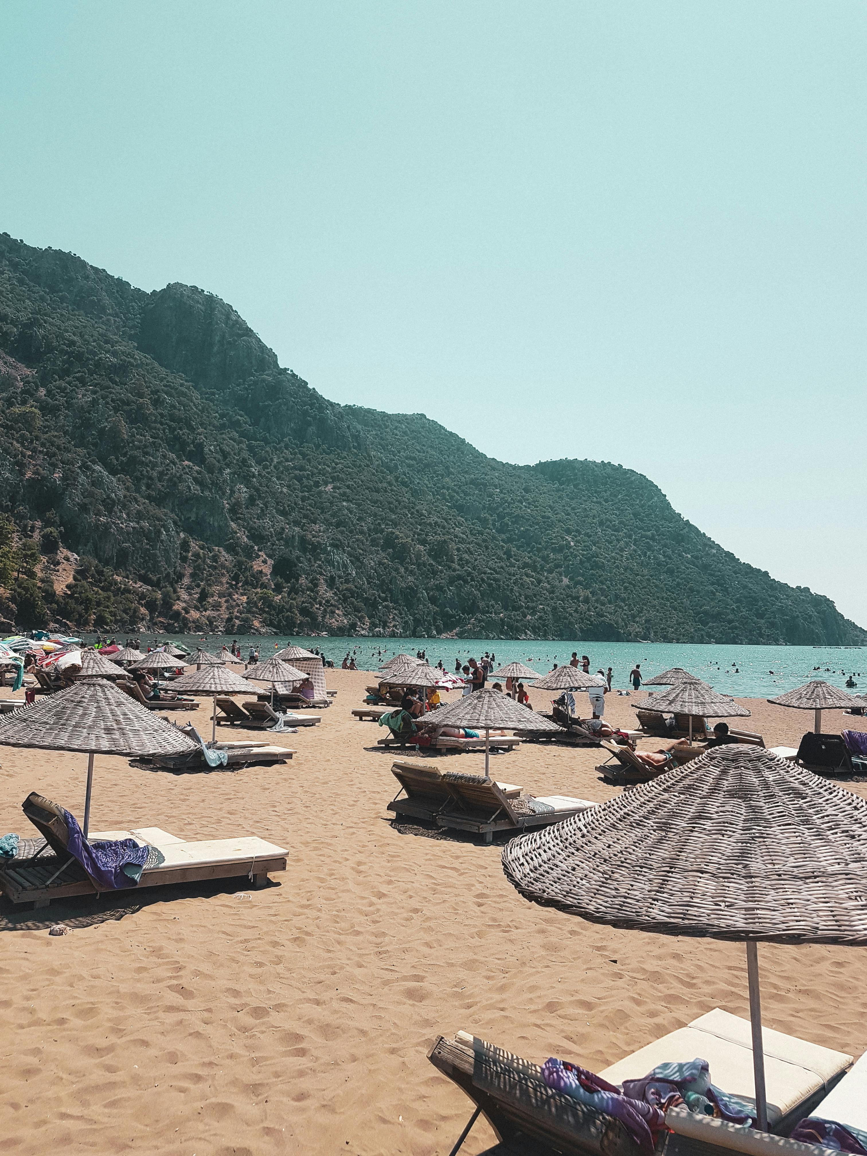 Low Angle View of Woman Relaxing on Beach Against Blue Sky · Free Stock ...