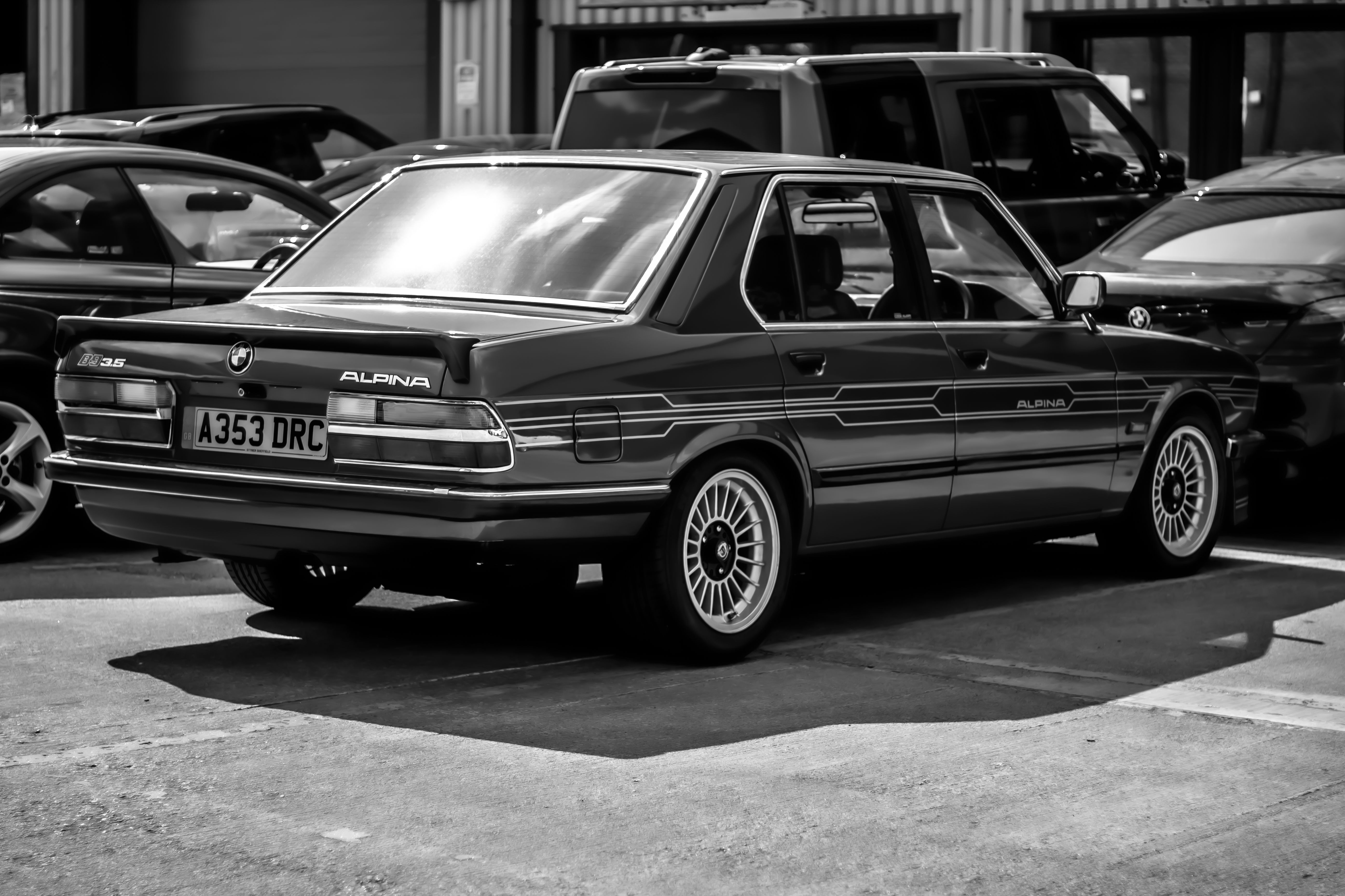 Grayscale Photo of a Parked Car · Free Stock Photo