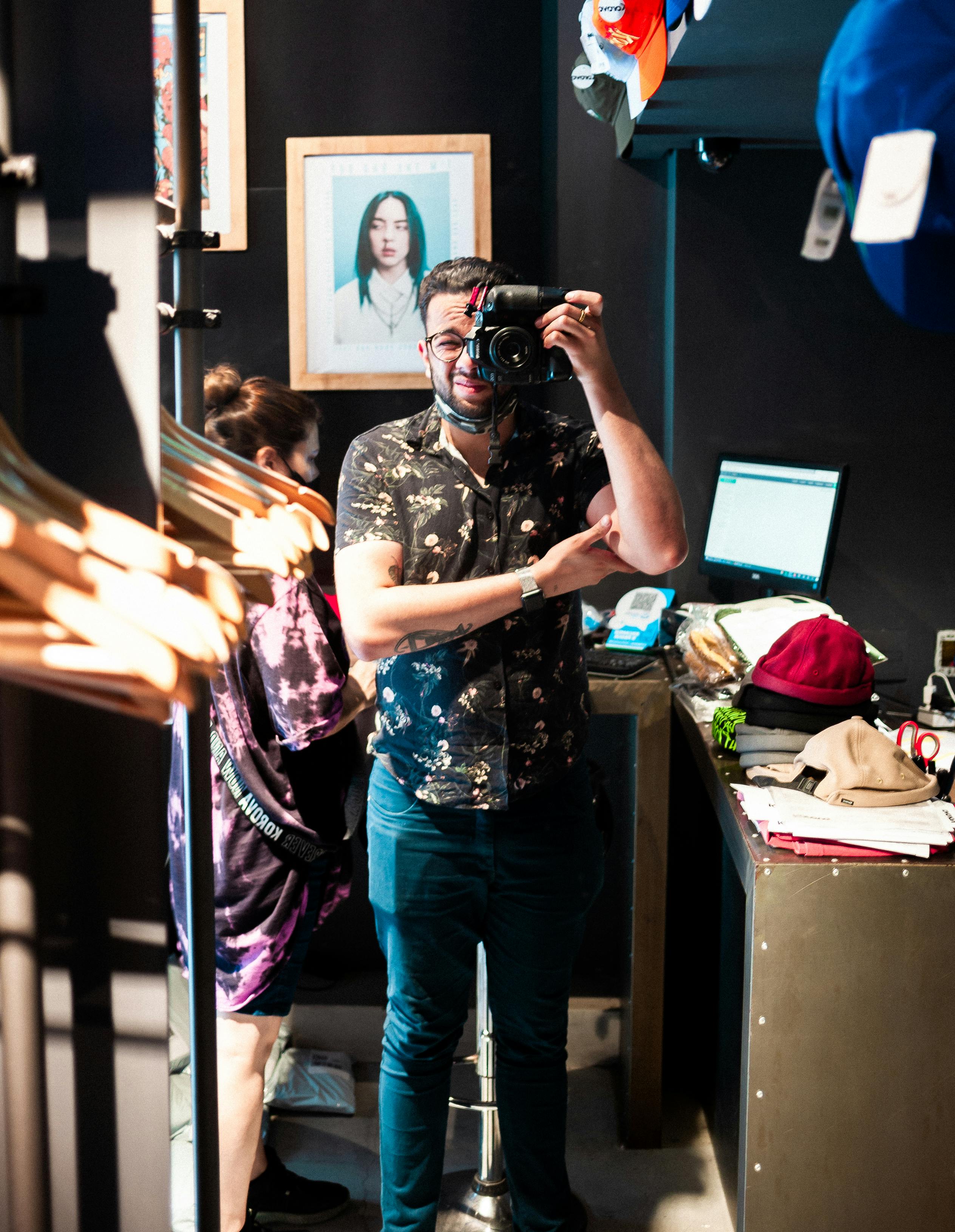 Man Inside a Clothing Store Holding a Camera Over His Eye · Free Stock ...
